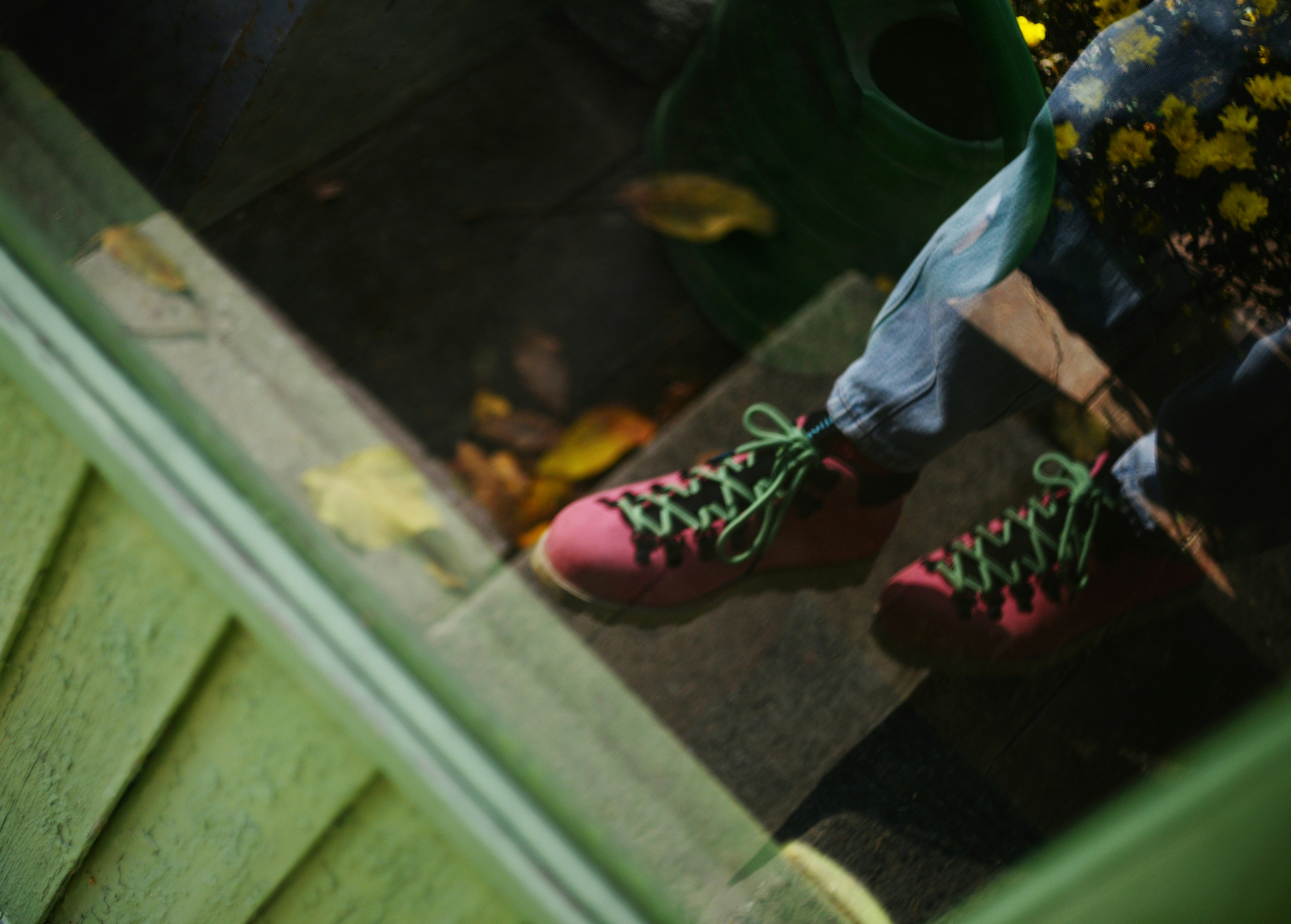 Colorful Trail Between Reflections: Shoes and Flowers on a Glass Window