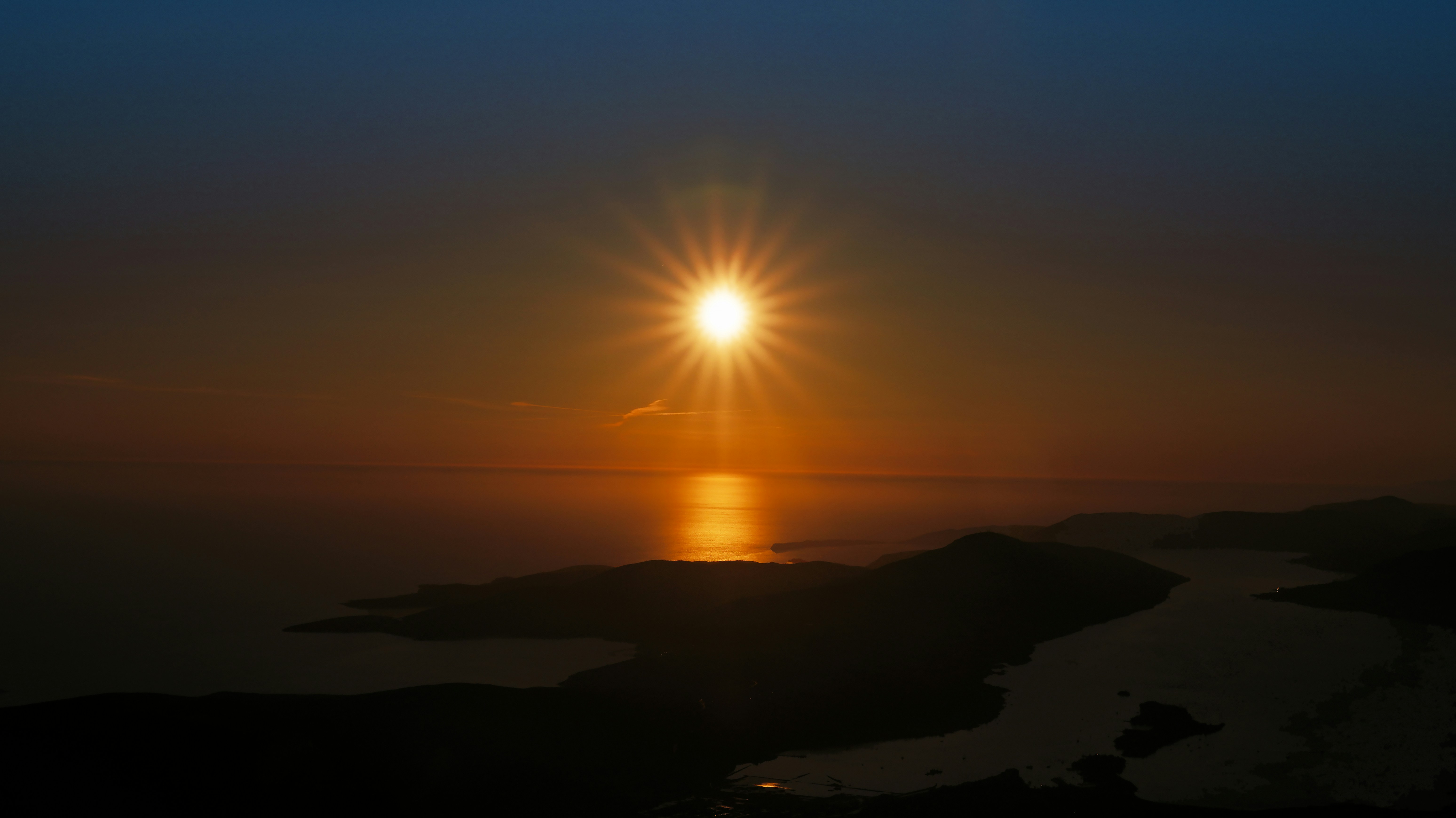 Sunfire Over Quiet Waters: A Distant Coast in Dusk