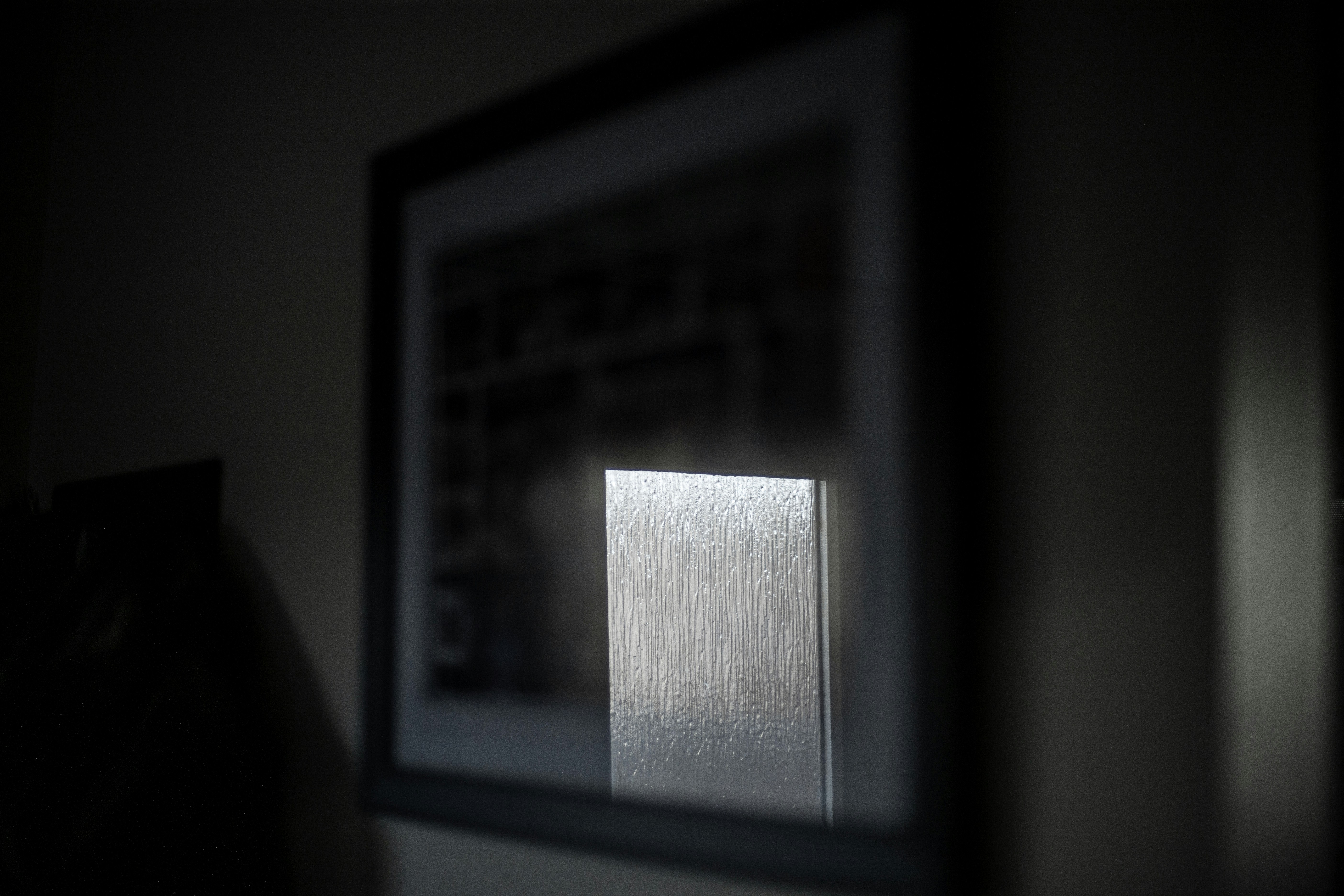 Backlit Window Frame: A Quiet Sliver of Light in the Dark Interior