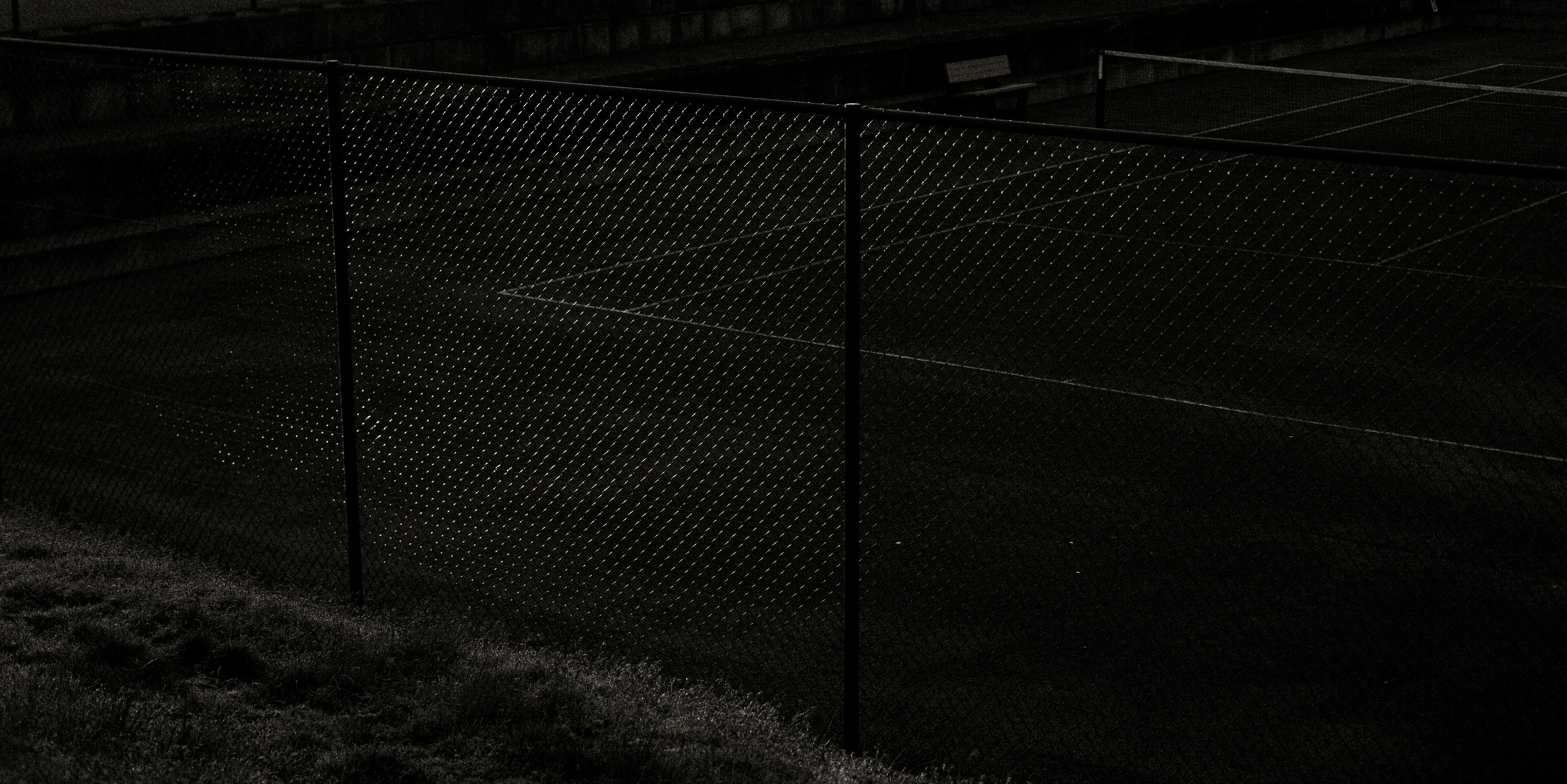 Shadowed Fence Under Stadium Lights