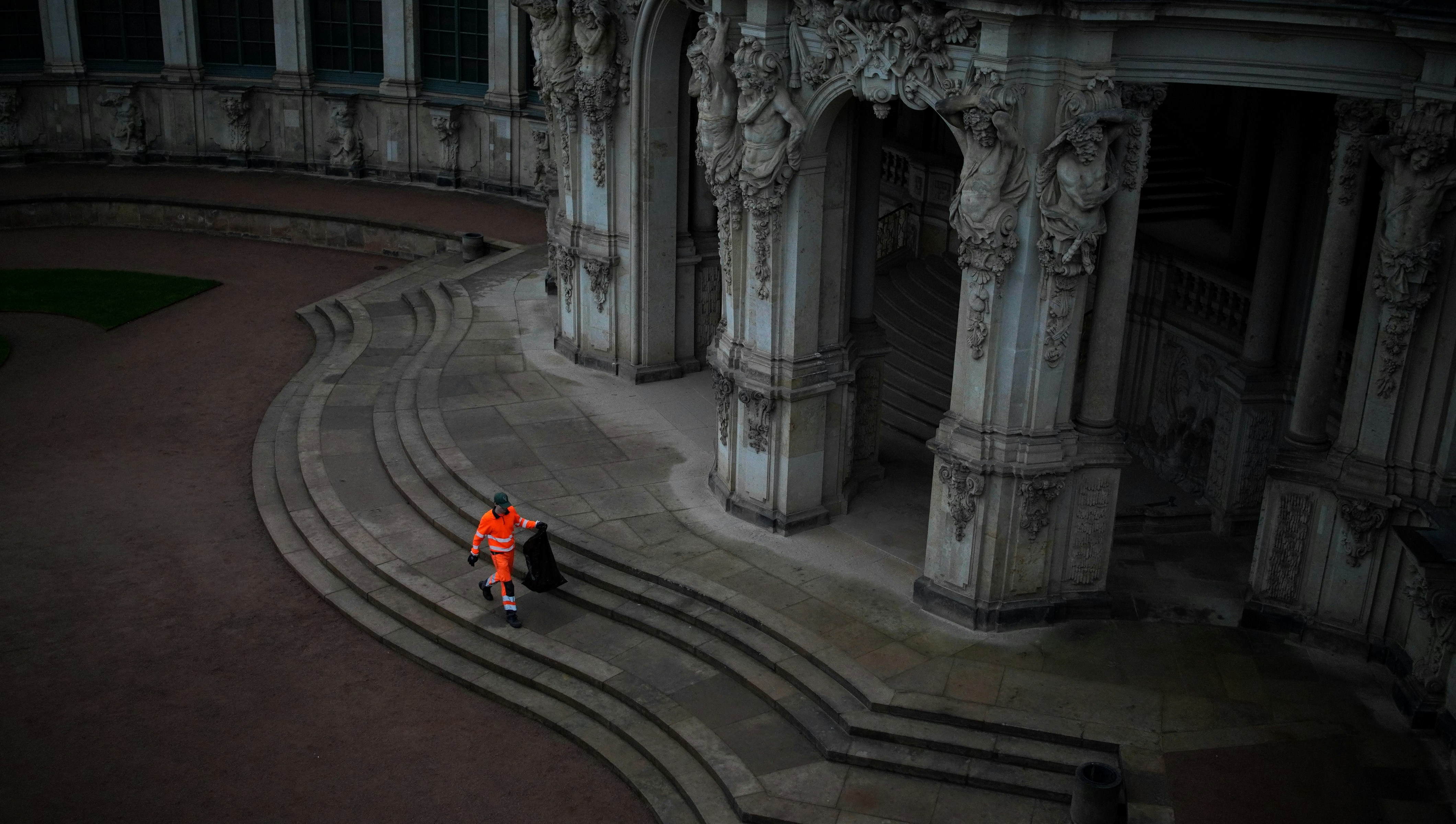 Orange-Clad Worker on the Crescent Steps beneath Historic Arches