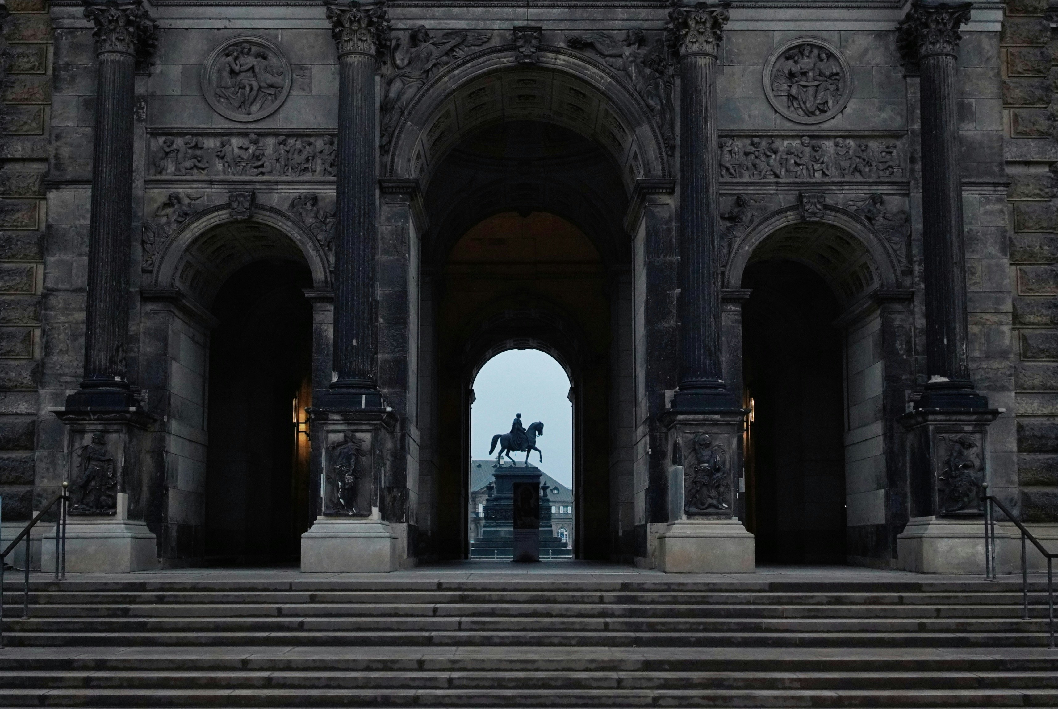 Gateway to the Silhouette: A stately arch framing a distant equestrian monument