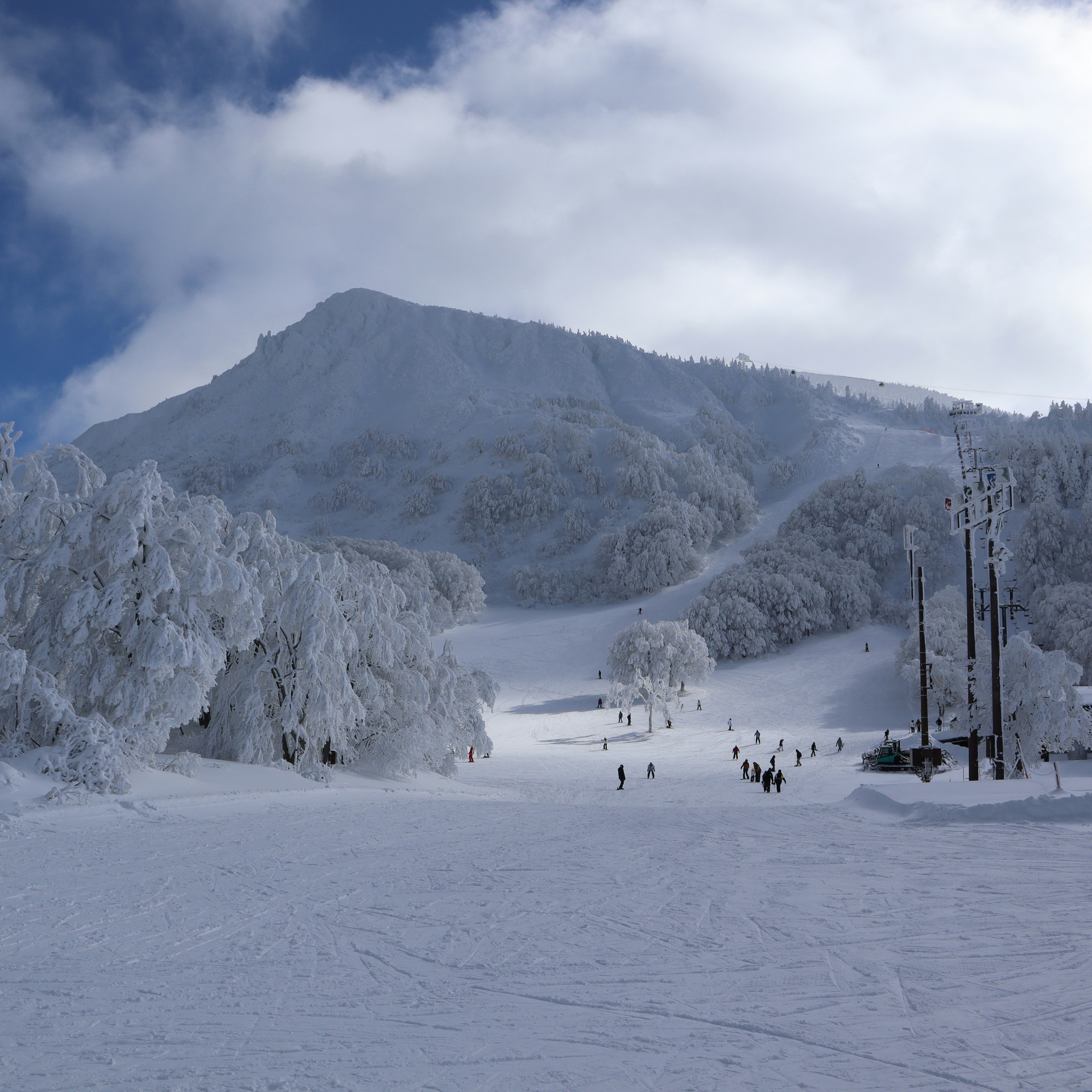 Snowbound Summit: Skiers Traverse a Quiet Alpine Slopescape