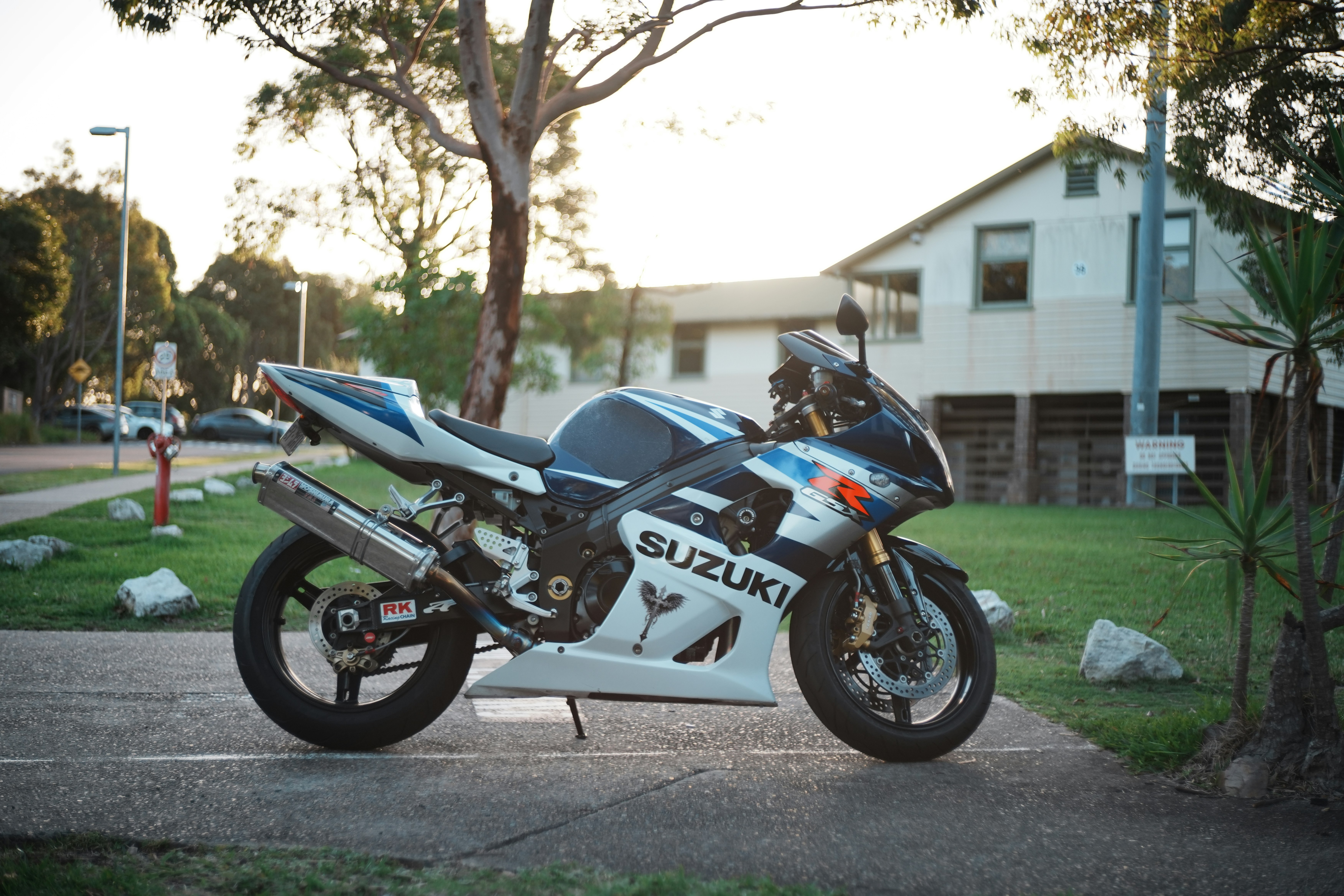 Silver Suzuki Moto on a Quiet Suburban Corner