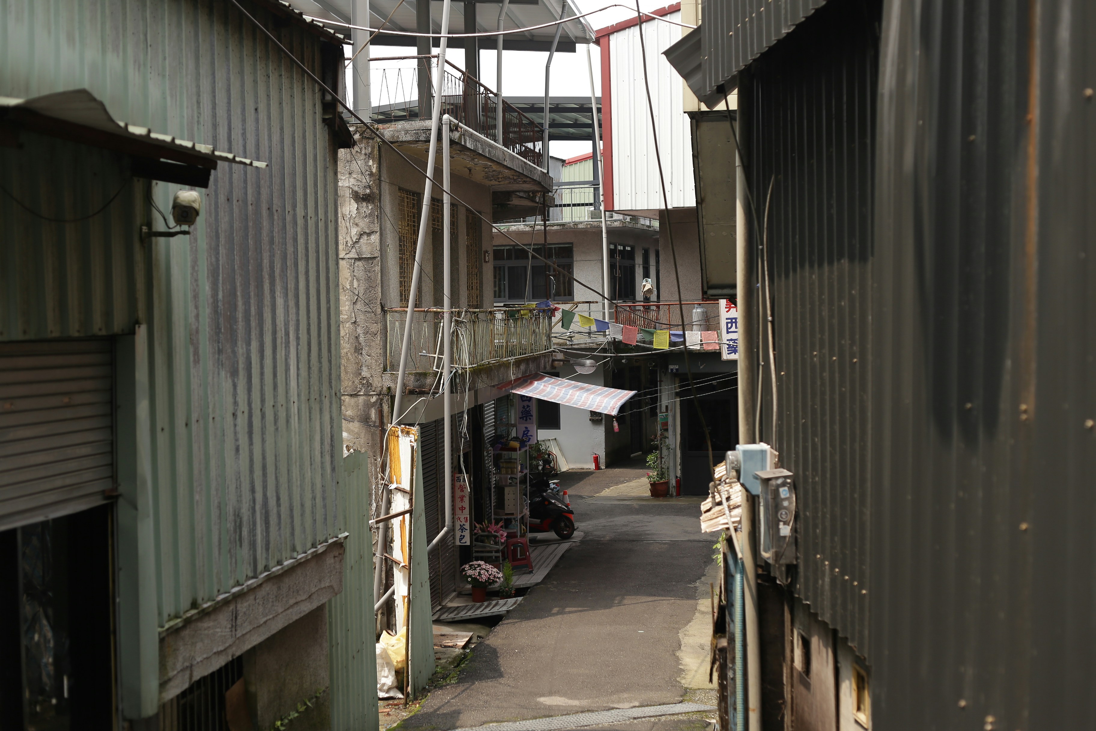 Narrow Alleyway’s Quiet Climb: A Concrete Corridor Between Corrugated Walls
