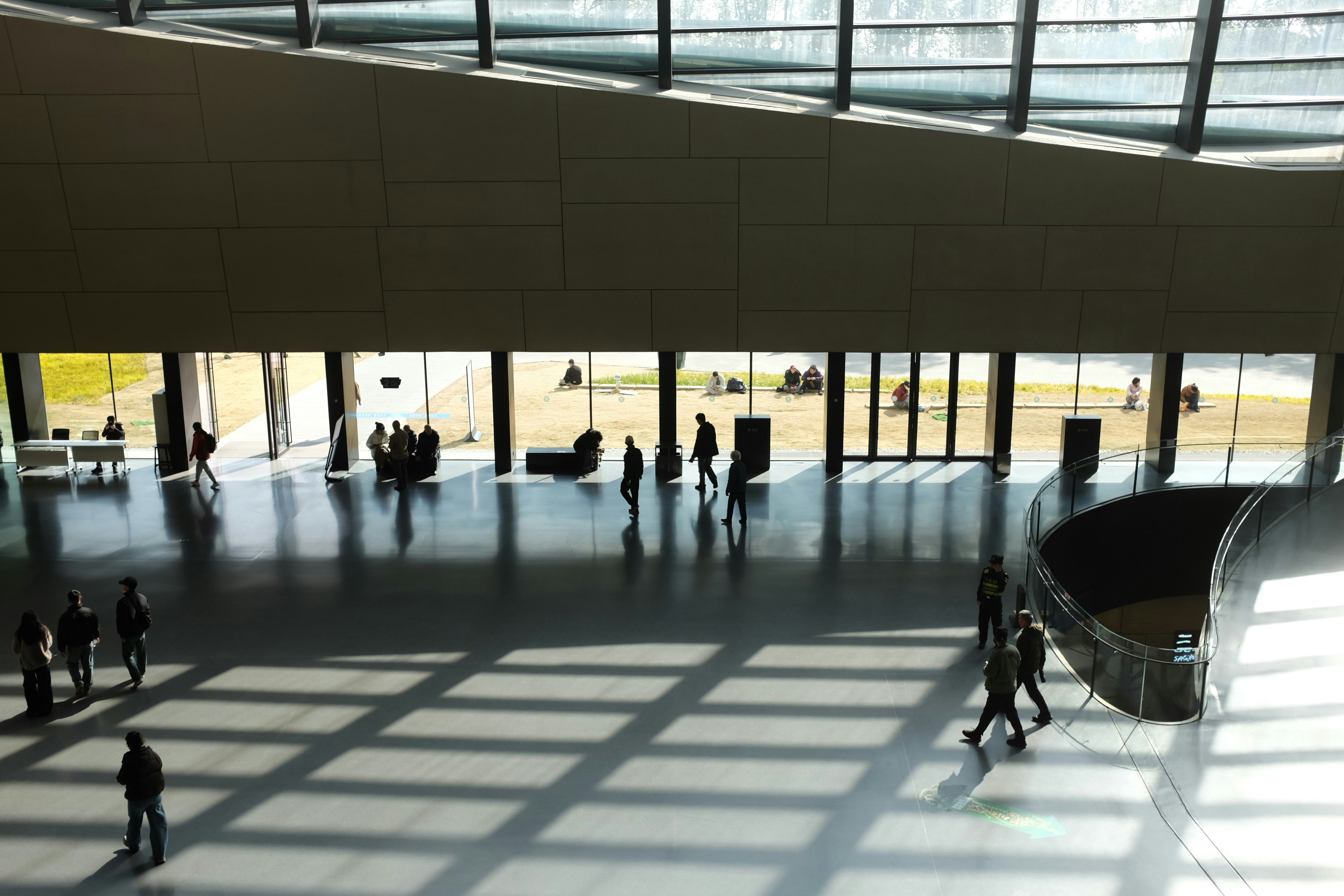 Sunlit Cutouts: People as Geometric Shadows in a Modern Atrium