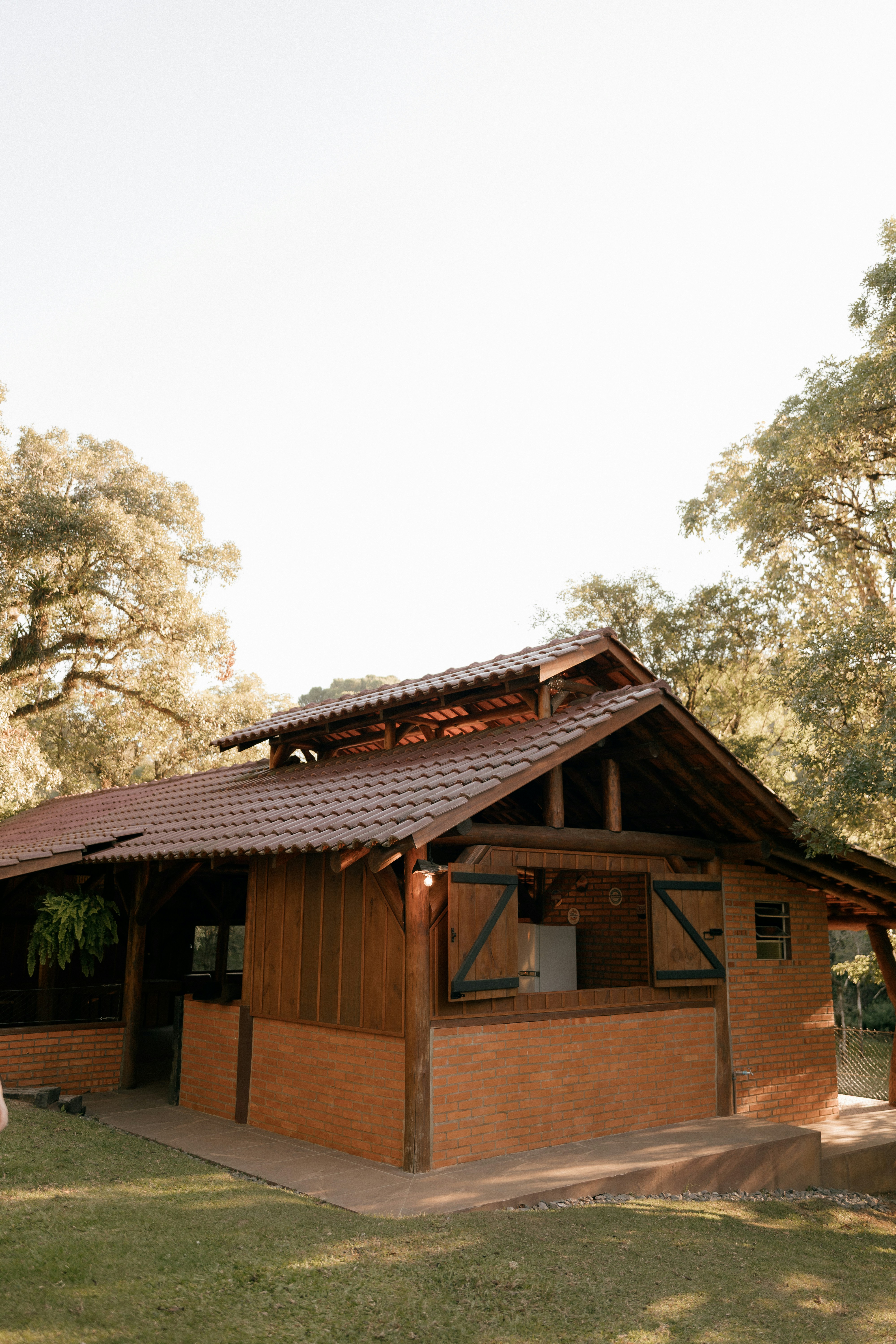 Rustic Brick Pavilion Under a Tiled Roof Amid Greenery