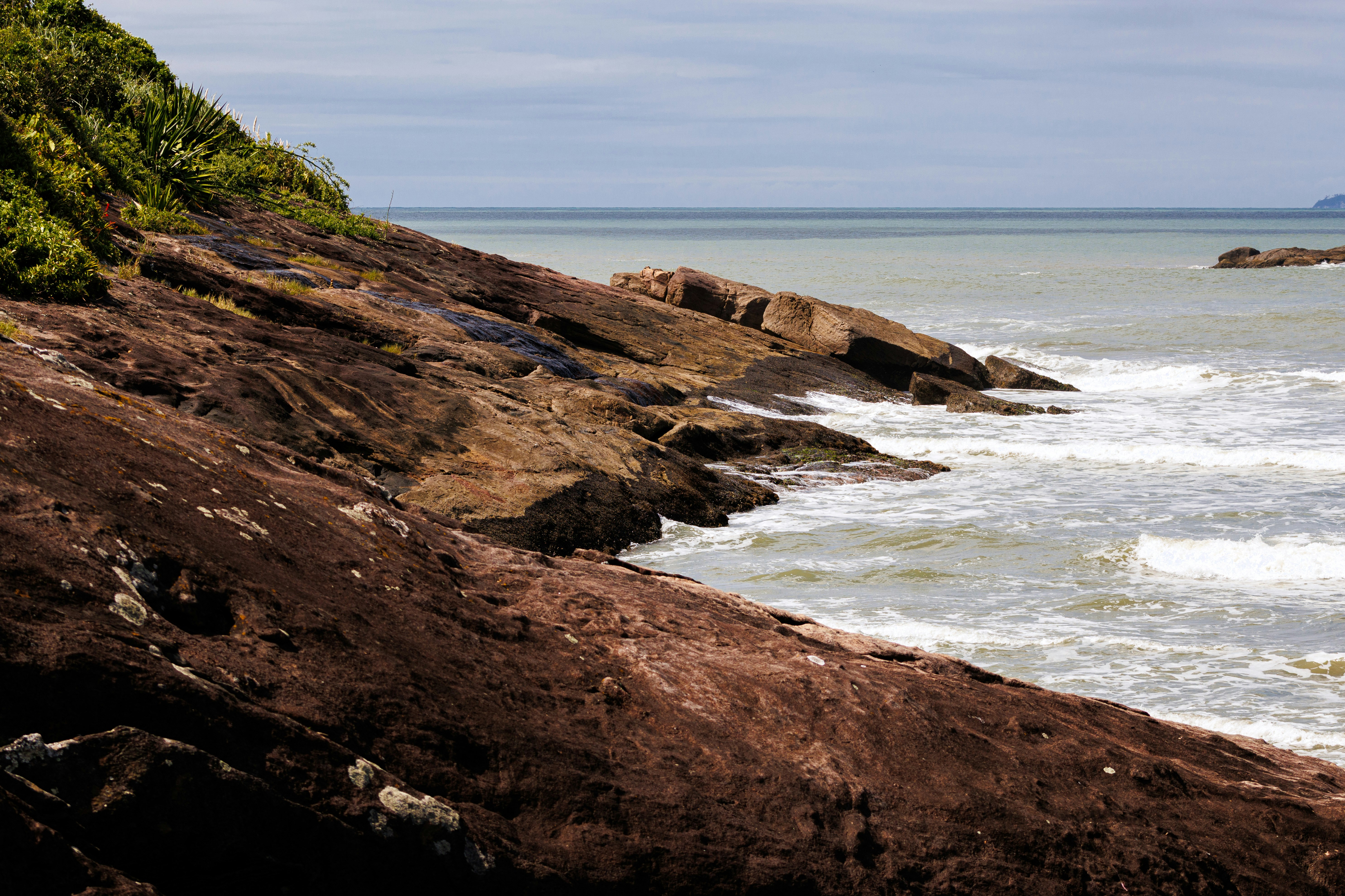 Rugged Tideline: Sunlit Granite Meets Quiet Sea
