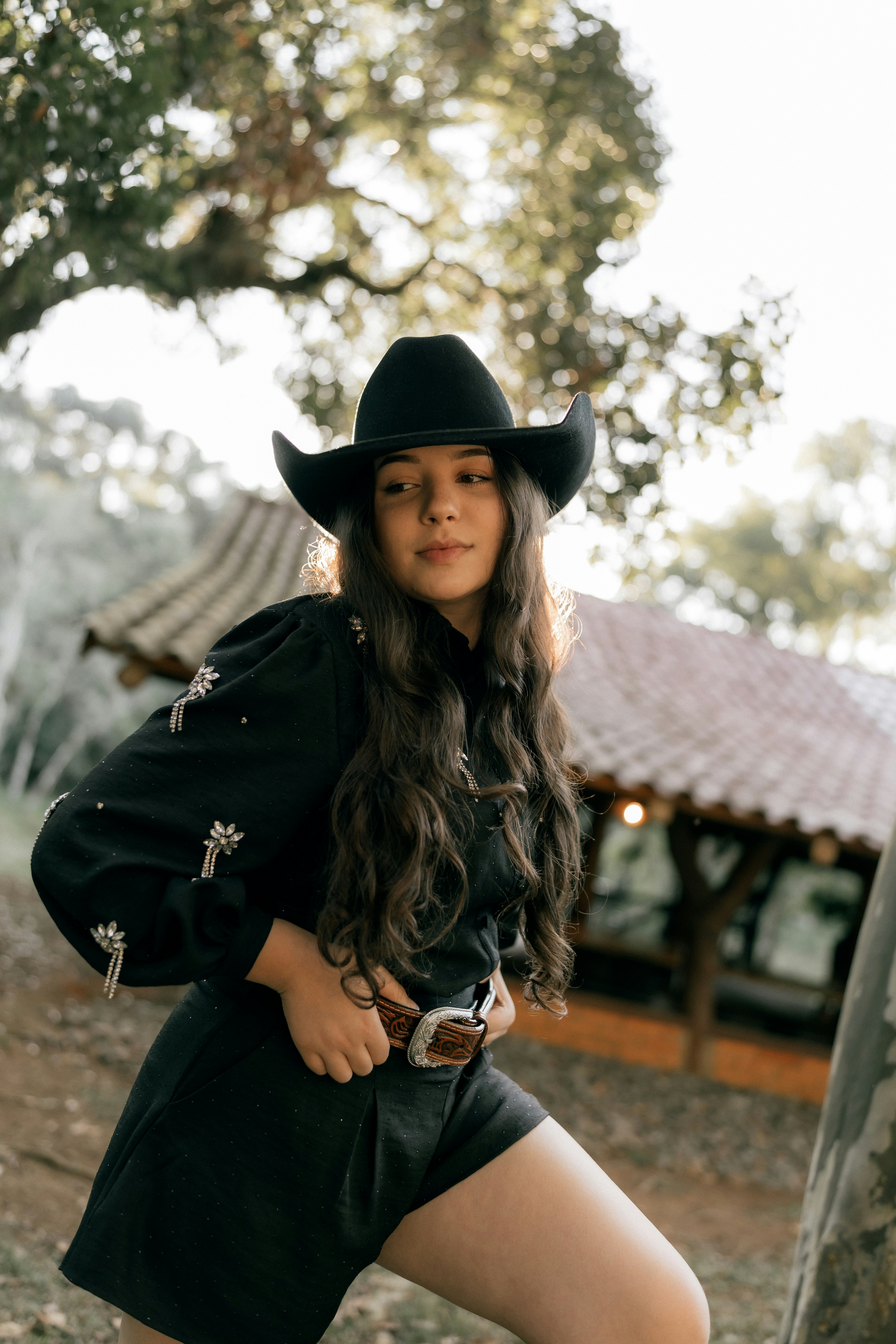 Cowgirl in Spotlight: A Self-Assured Pose by the Ranch House