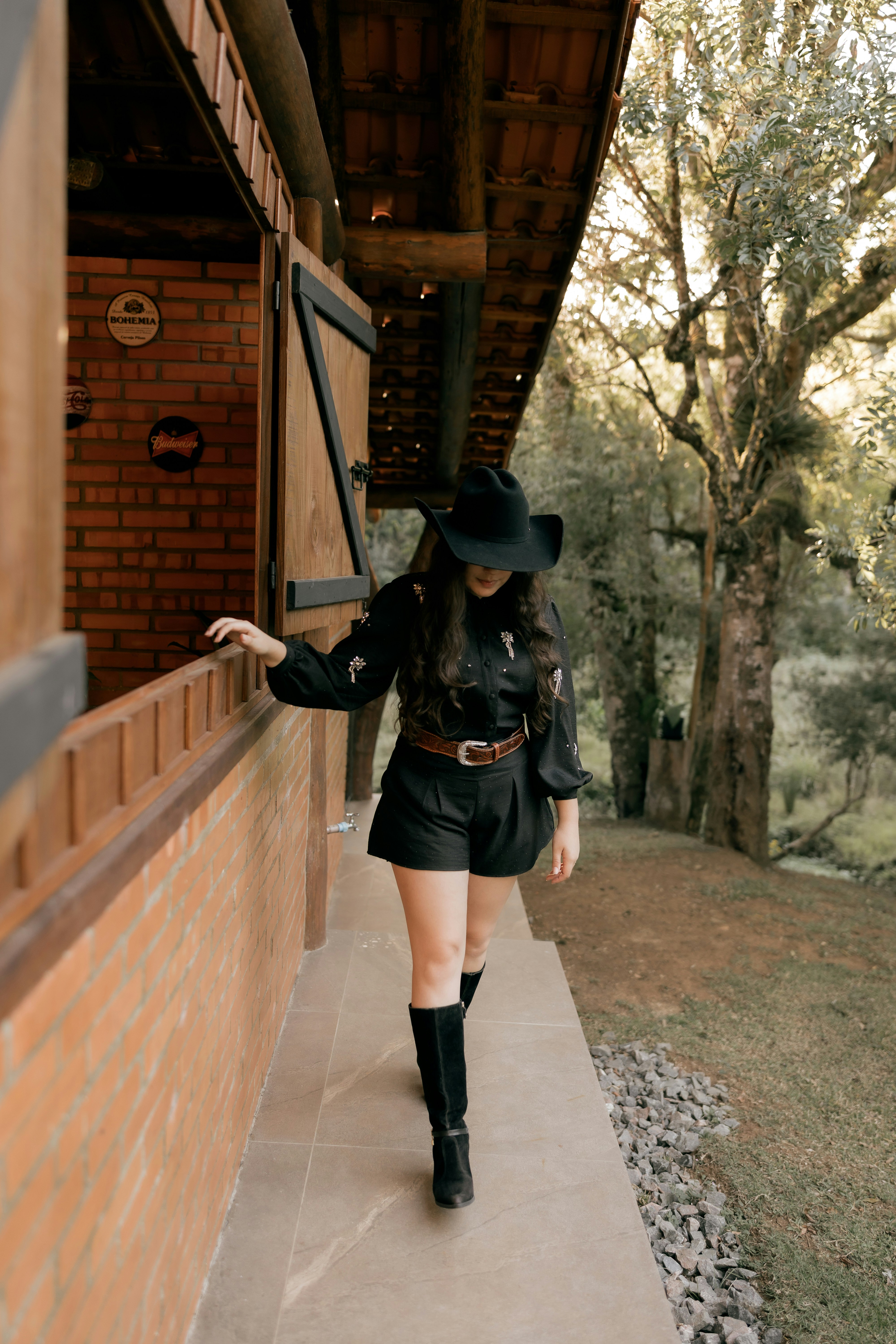 Cowgirl in Black: A Quiet Poise Along a Wooden Gallery