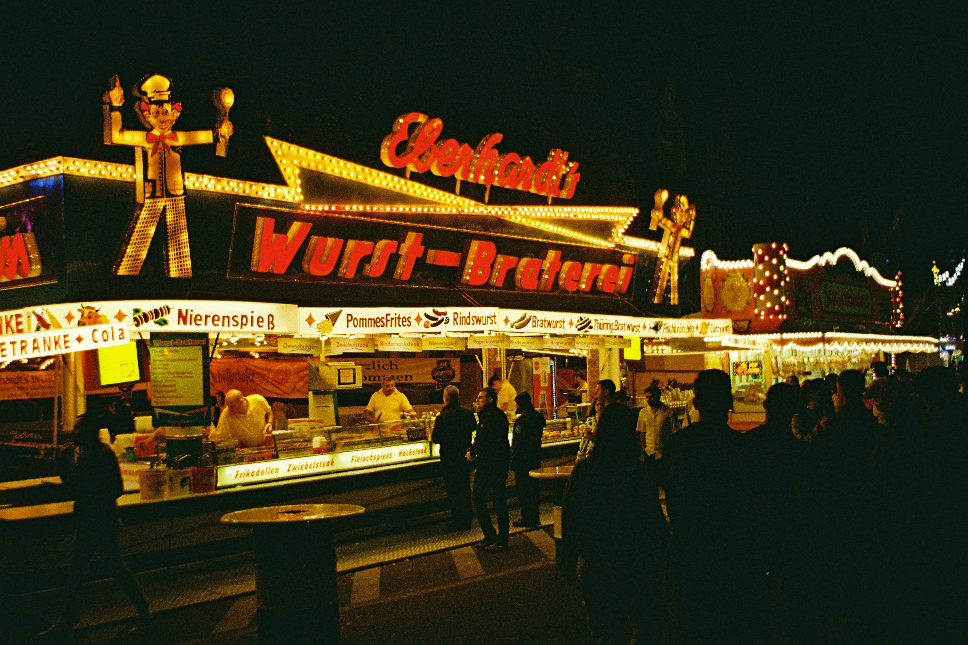 Neon Carnival Grill: Night Lights and Hungry Crowds at the Food Stalls