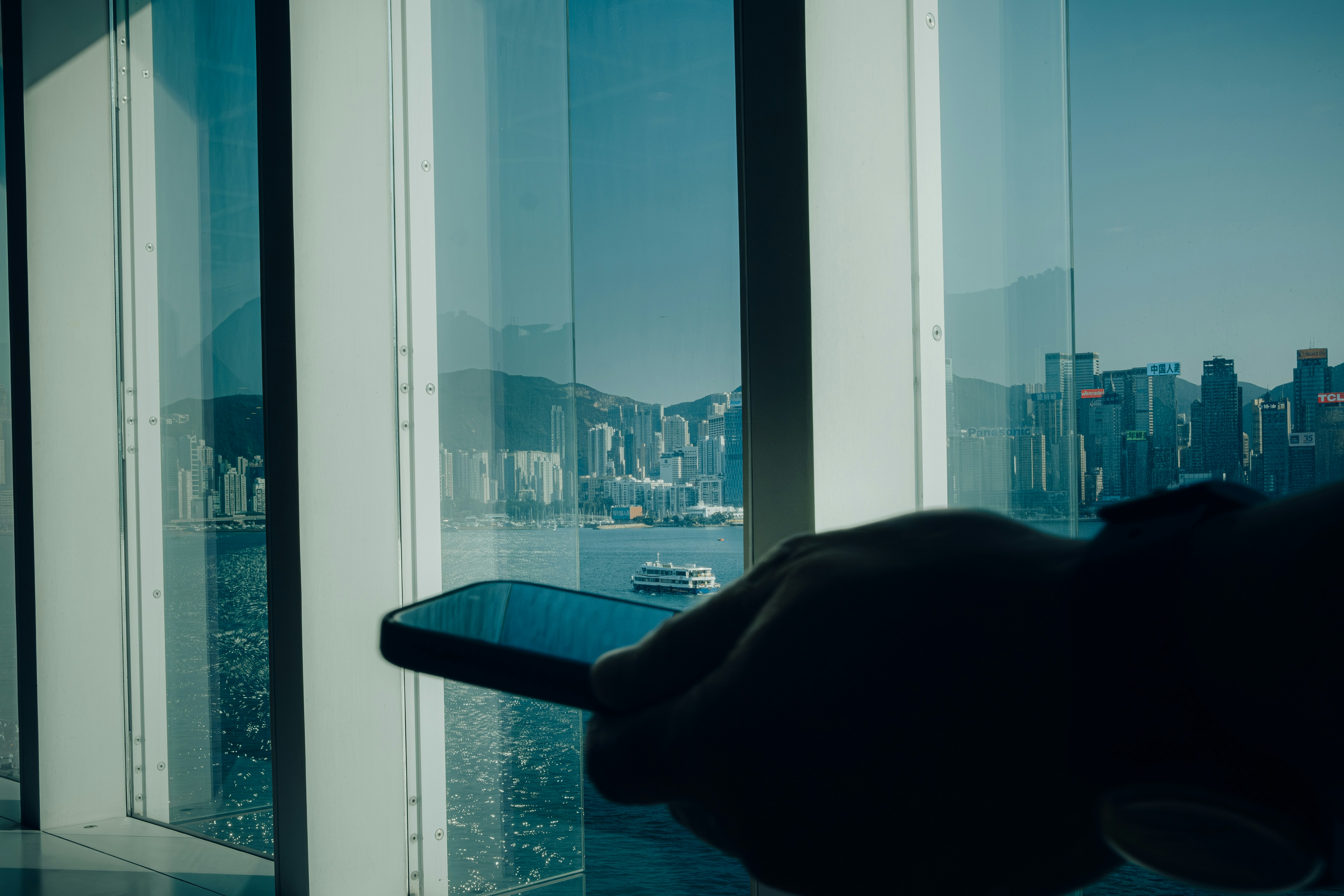 Cityscape through Glass: A Quiet Hand with a Smartphone