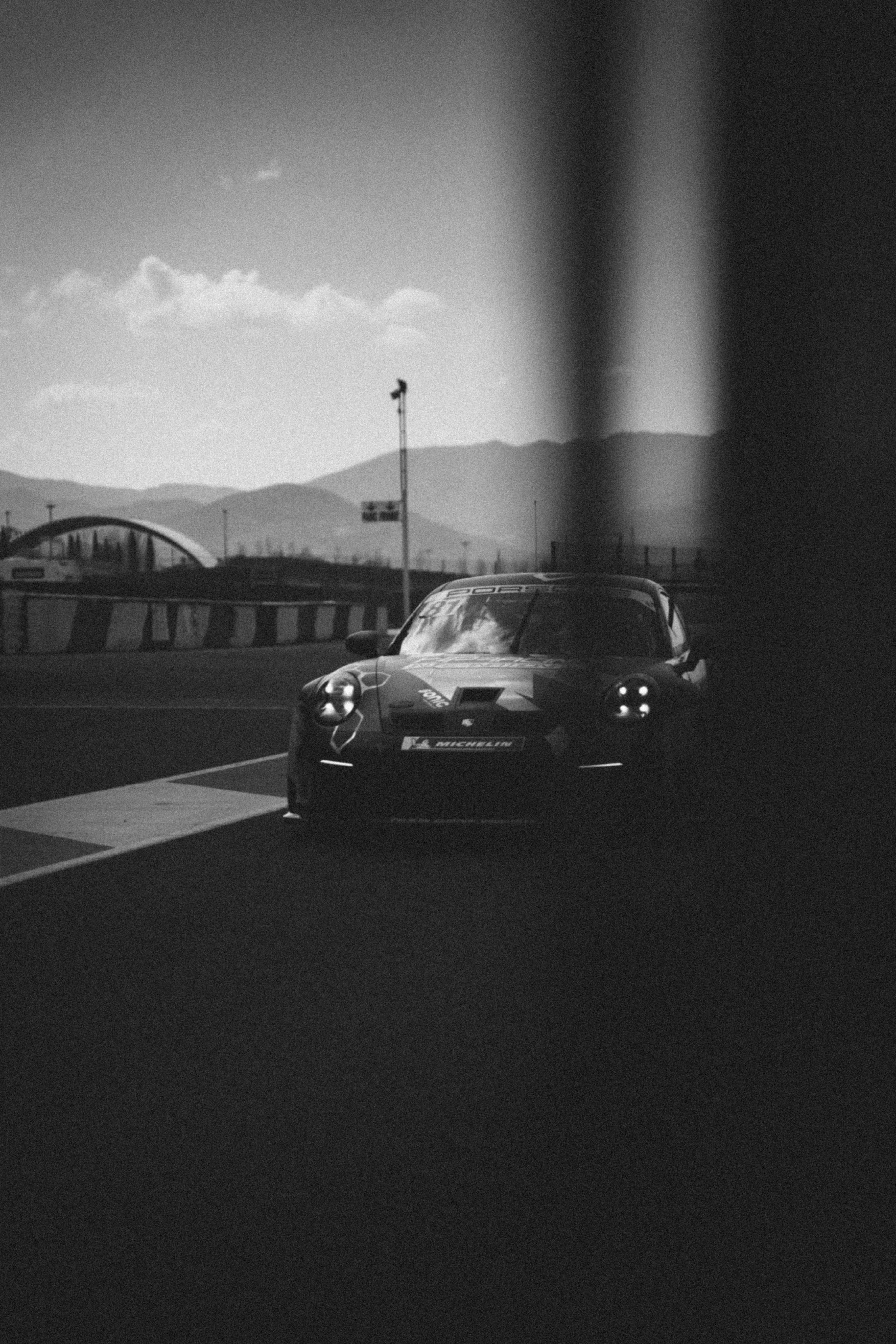 Midfield Racer in Shadow: A Car Emerges from the Frame