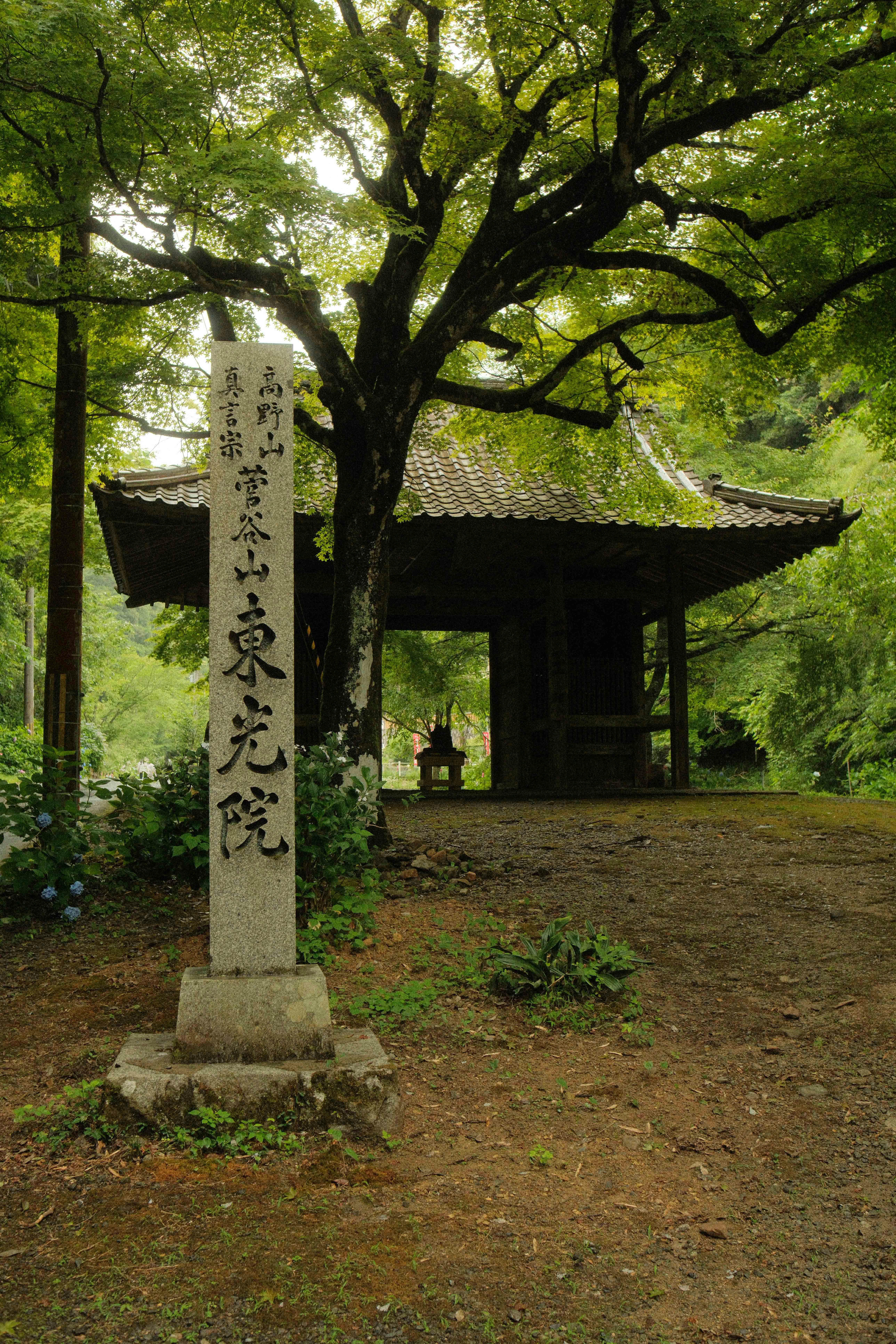 Stone monument in front of a japanese temple building.