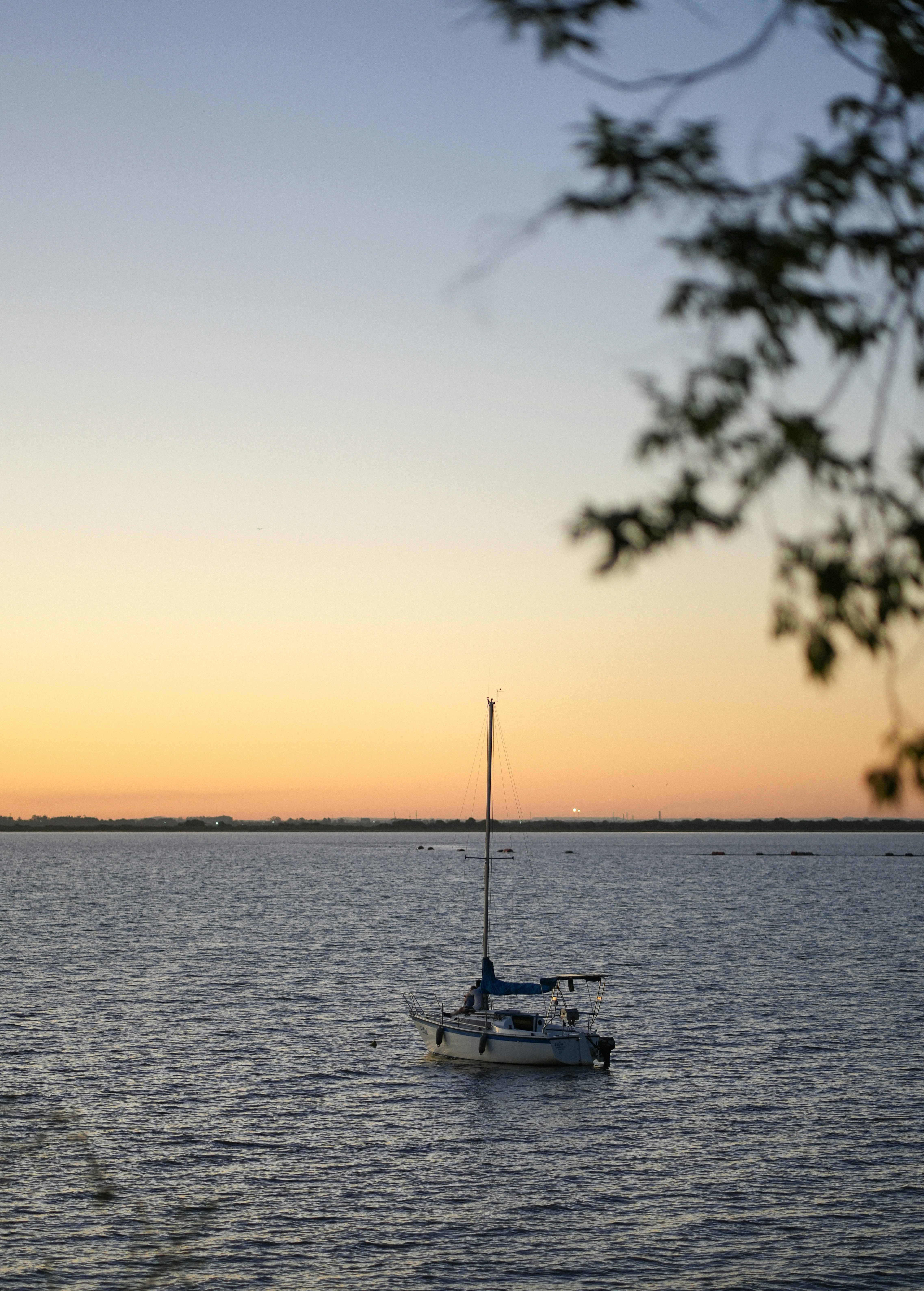 Sailboat at Dusk: A Quiet Horizon on Calm Waters
