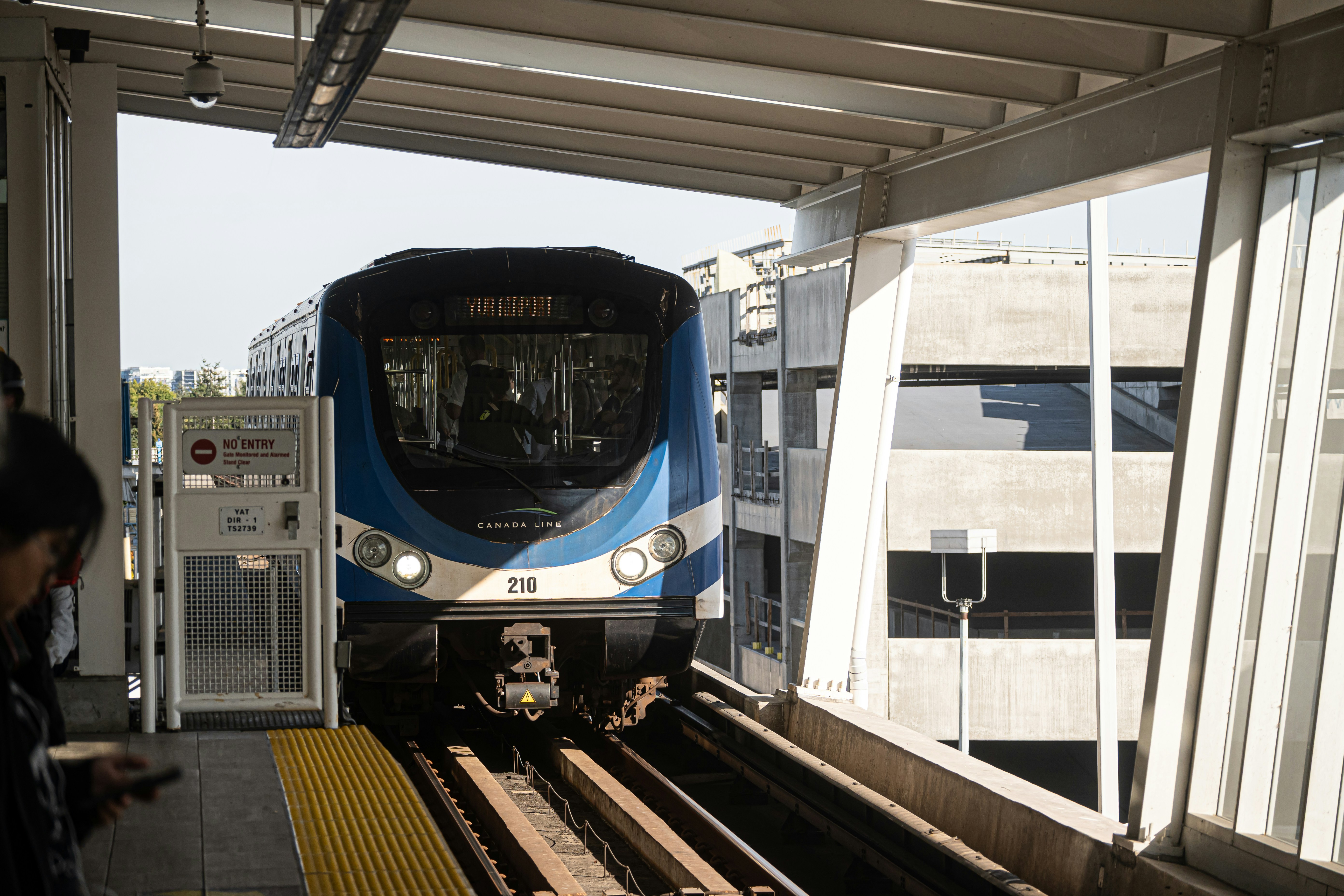 Front-on Transit: Blue Metro Train Stopping at a Sunny Platform