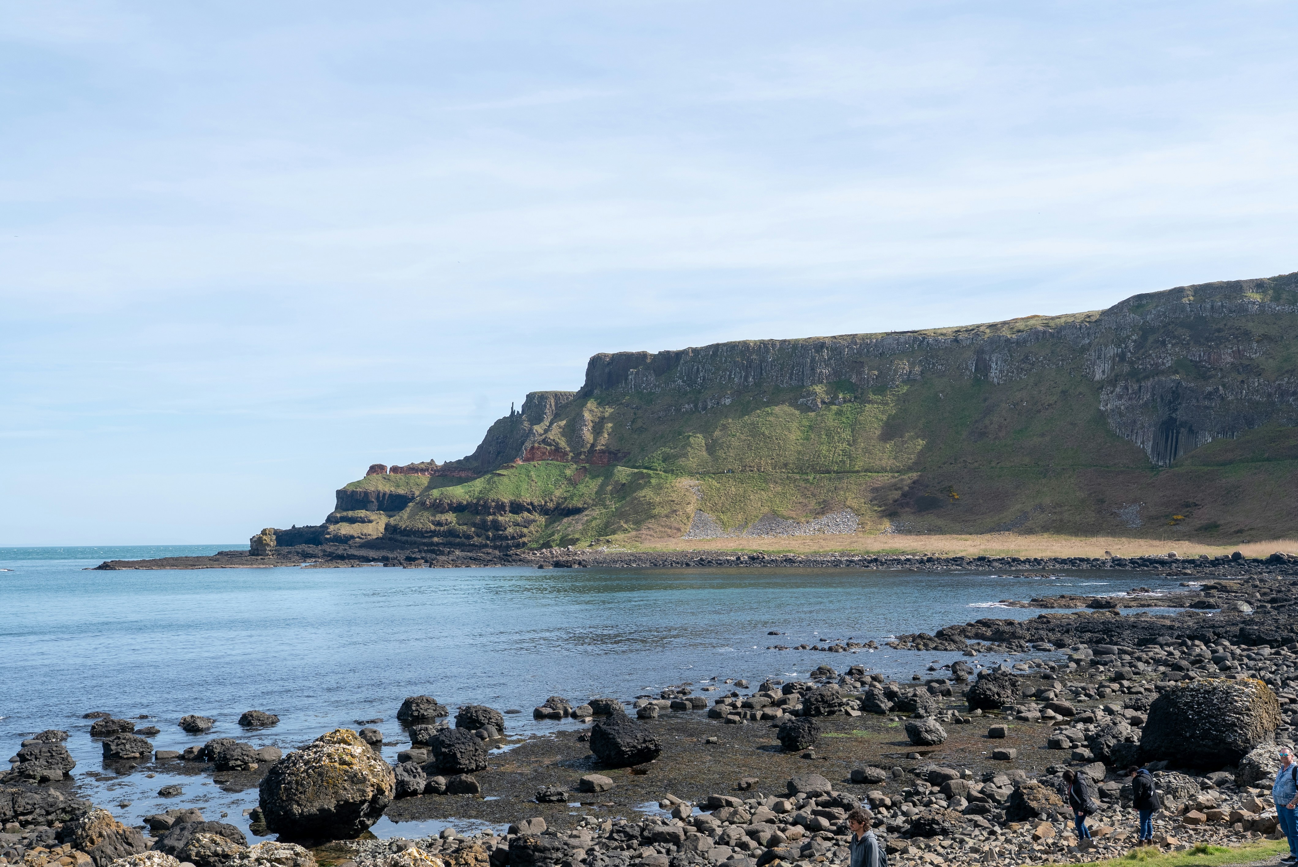 Rugged shoreline beneath towering coastal cliffs at low tide