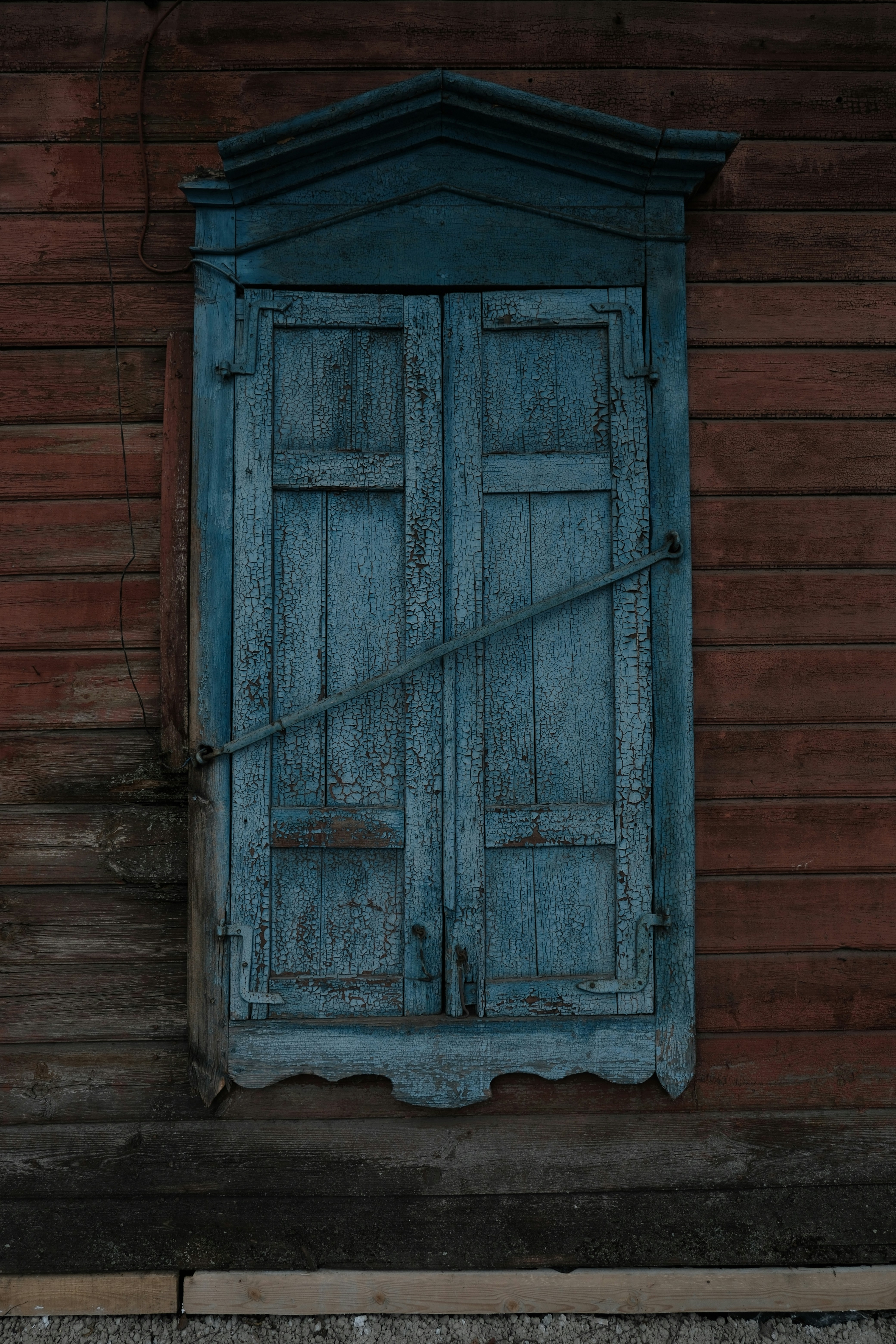 Weathered Blue Door on a Rustic Red Wall
