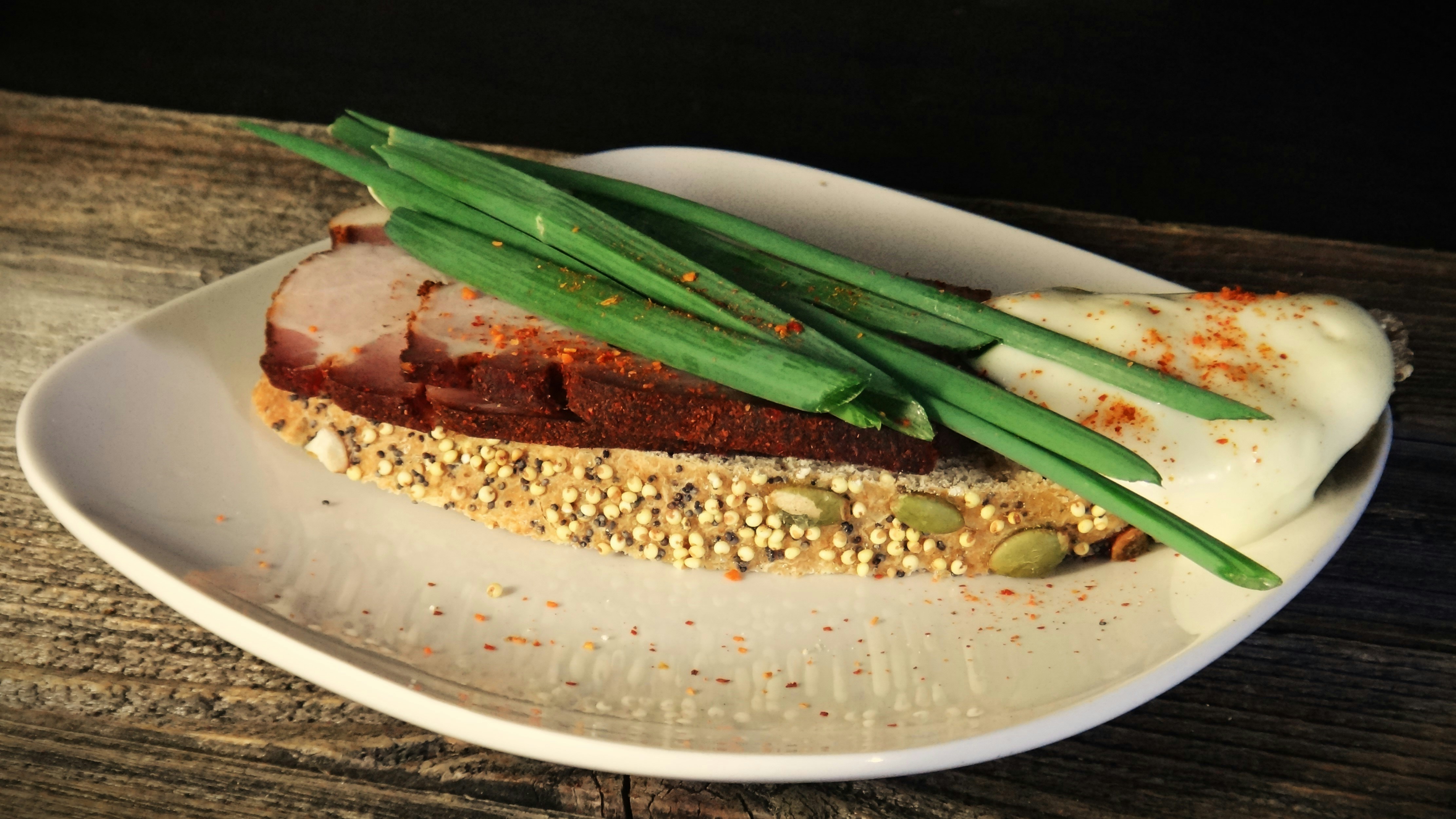 Savory Crunch: Seared Meat atop Nut-Crusted Bread with Creamy Dill Finish