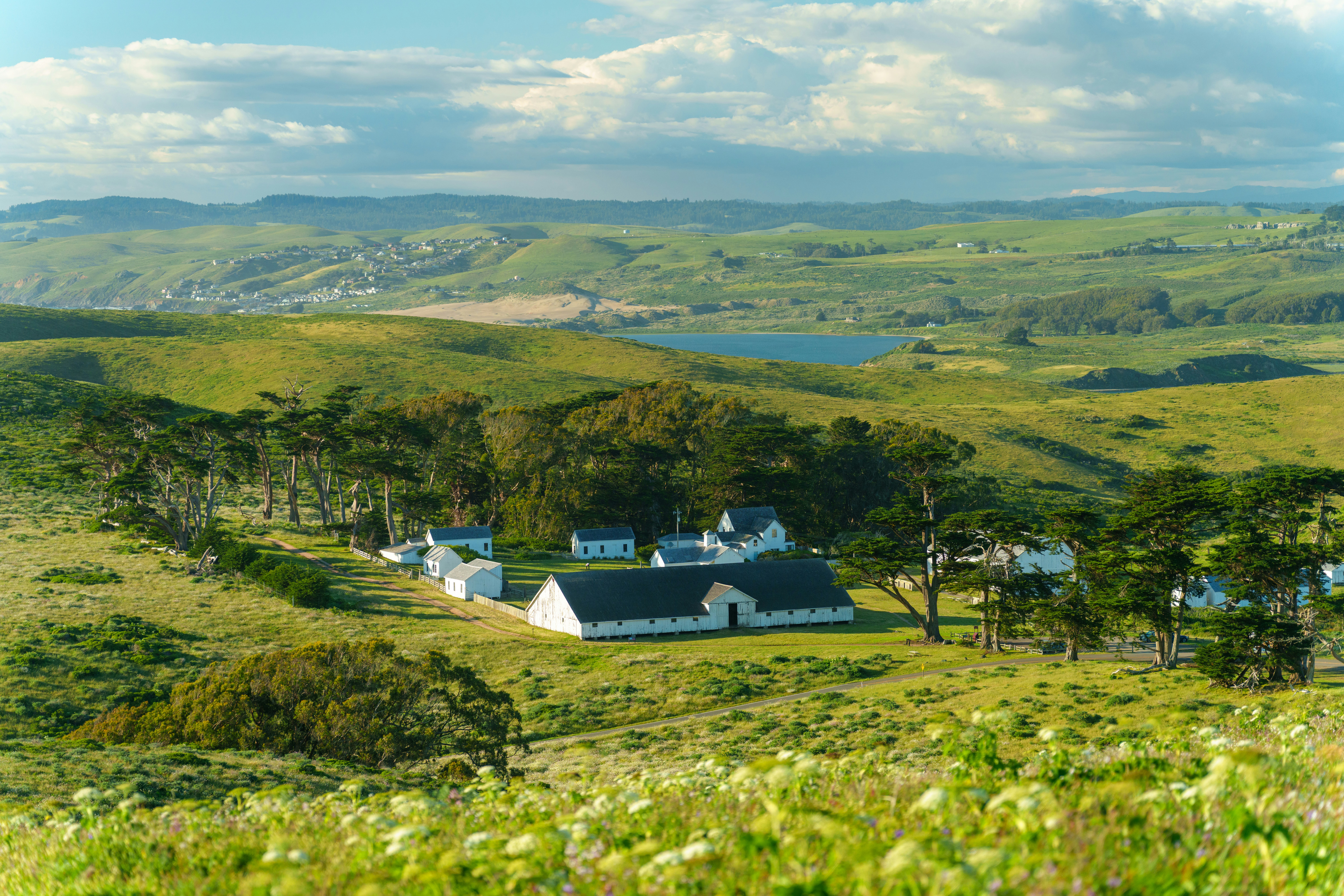 Pastoral Cliffs: White Farmstead Nestled in Rolling Coastal Hills