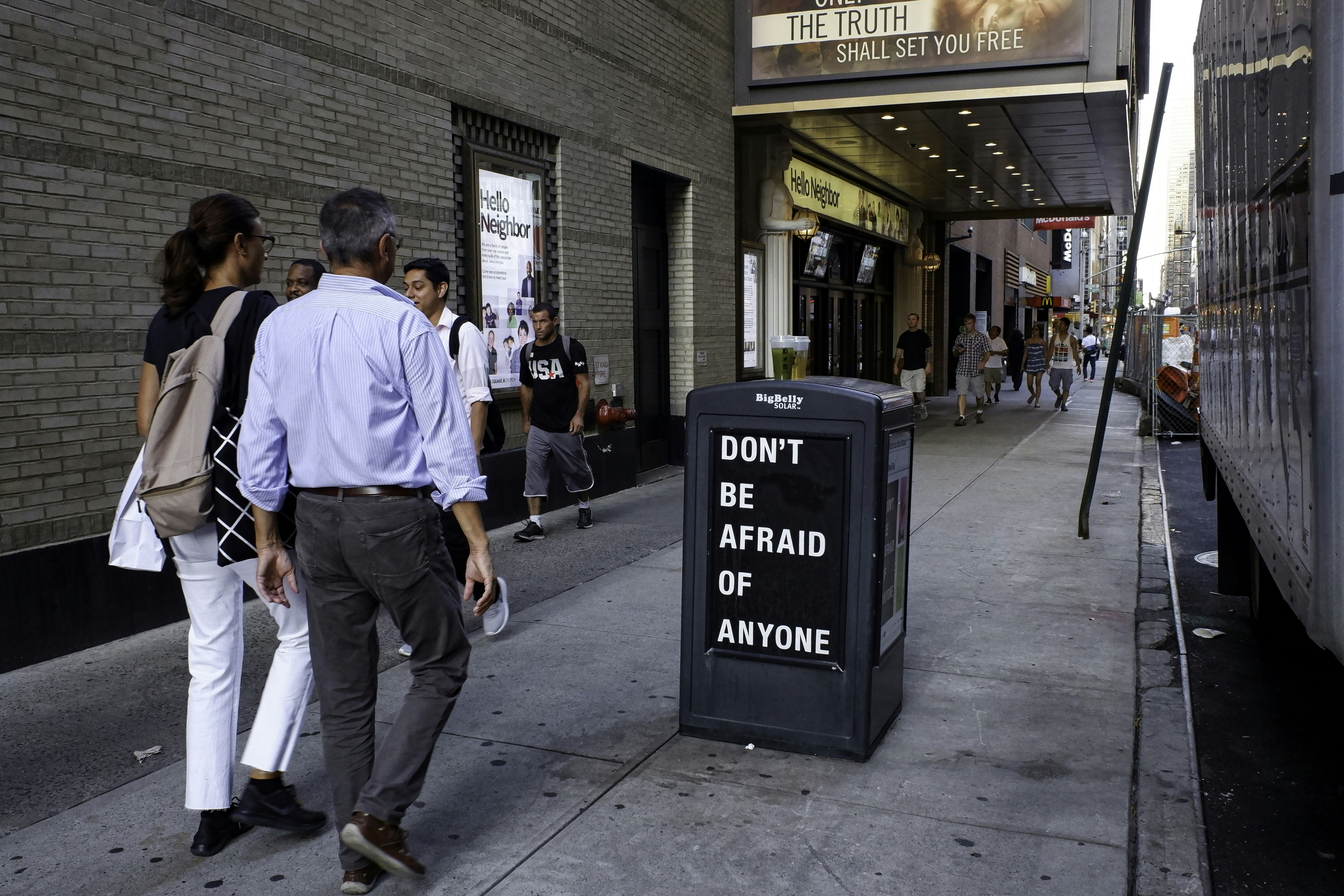 Street Conversation and Signage on a Bustling Sidewalk
