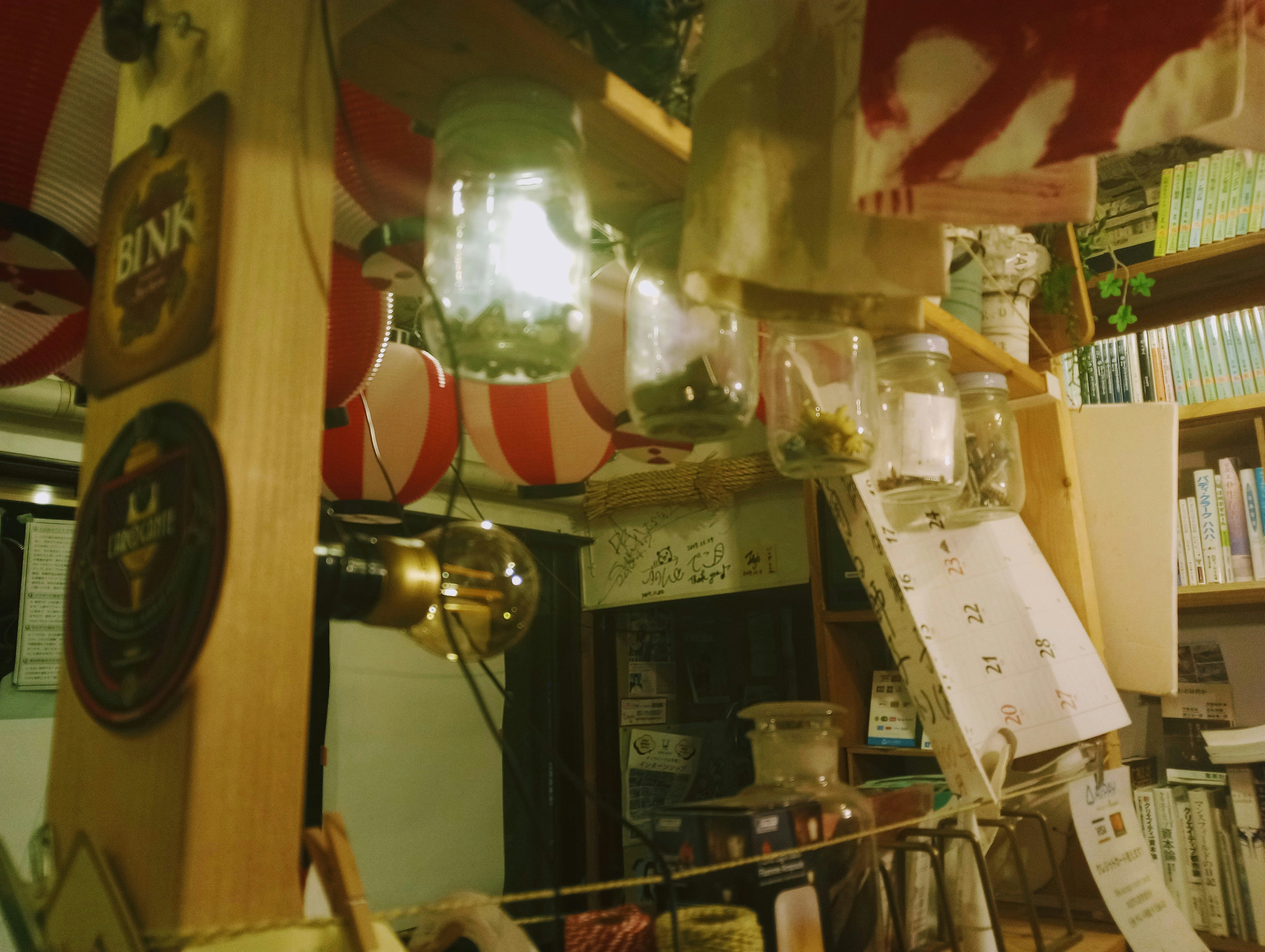 Shelves and Bottles Beneath Hanging Lanterns in a Cozy Shop
