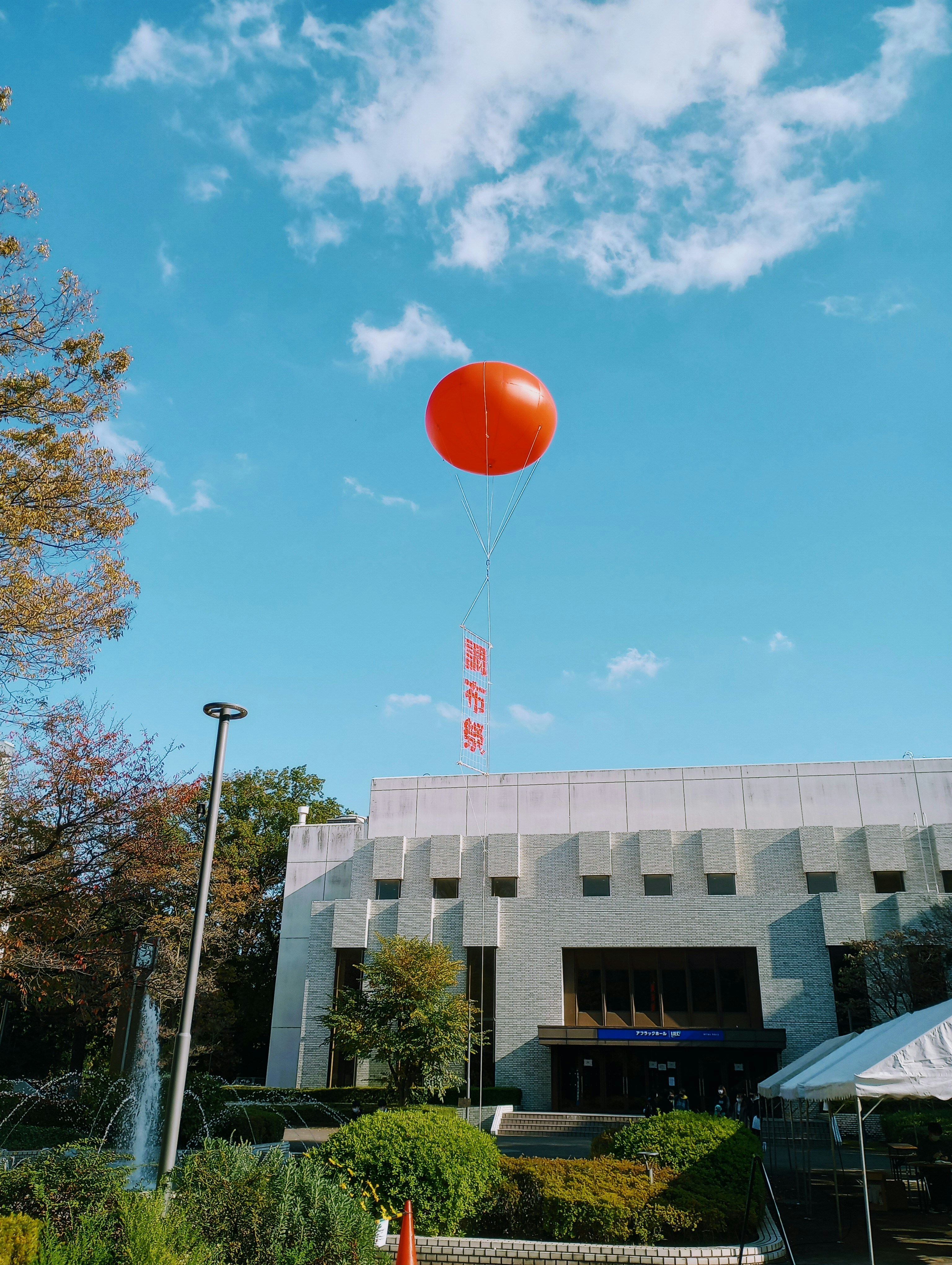Floating Red Beacon over a Modern campus Building