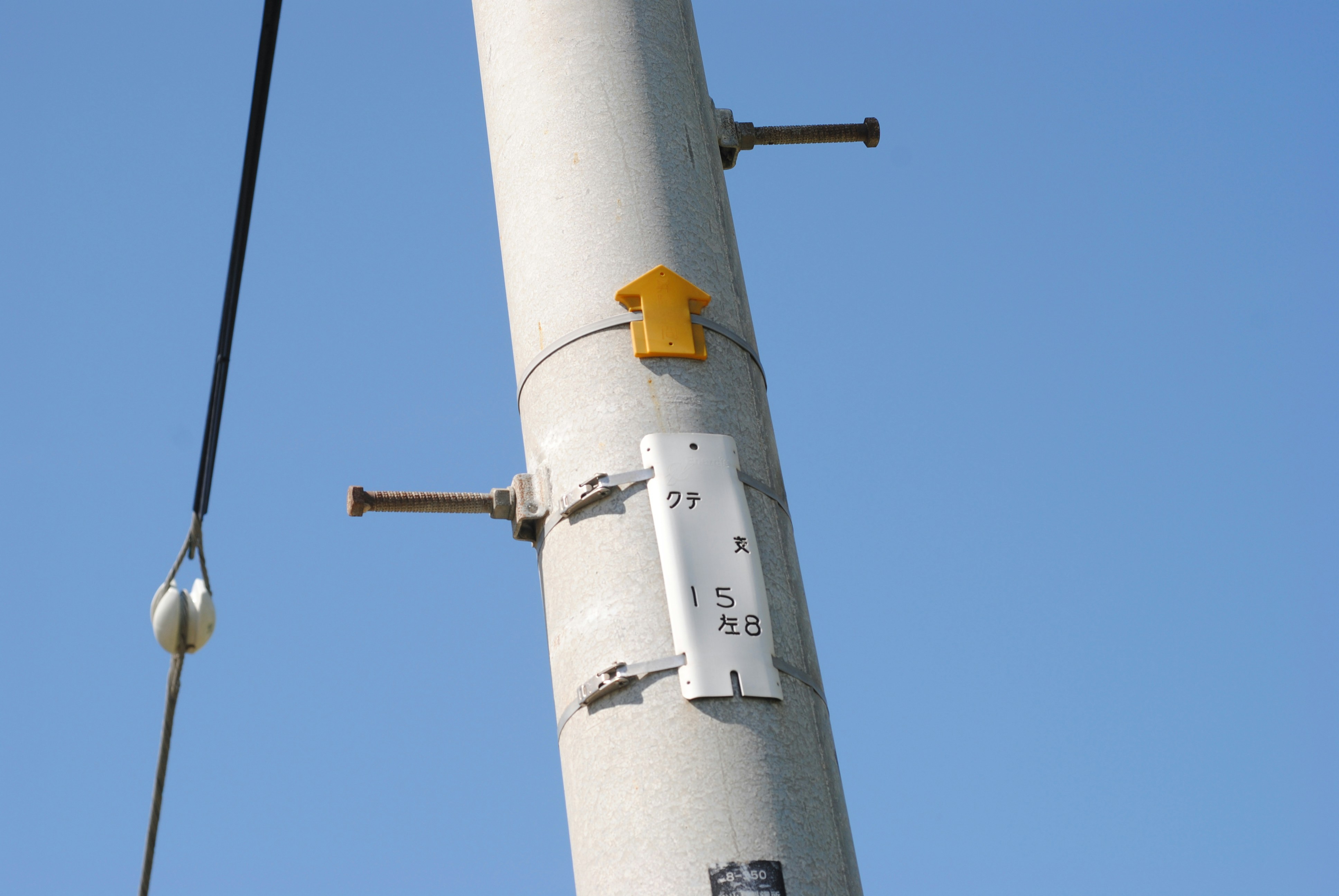 Vertical Utility Mast with an Orange Marker Against a Clear Blue Sky