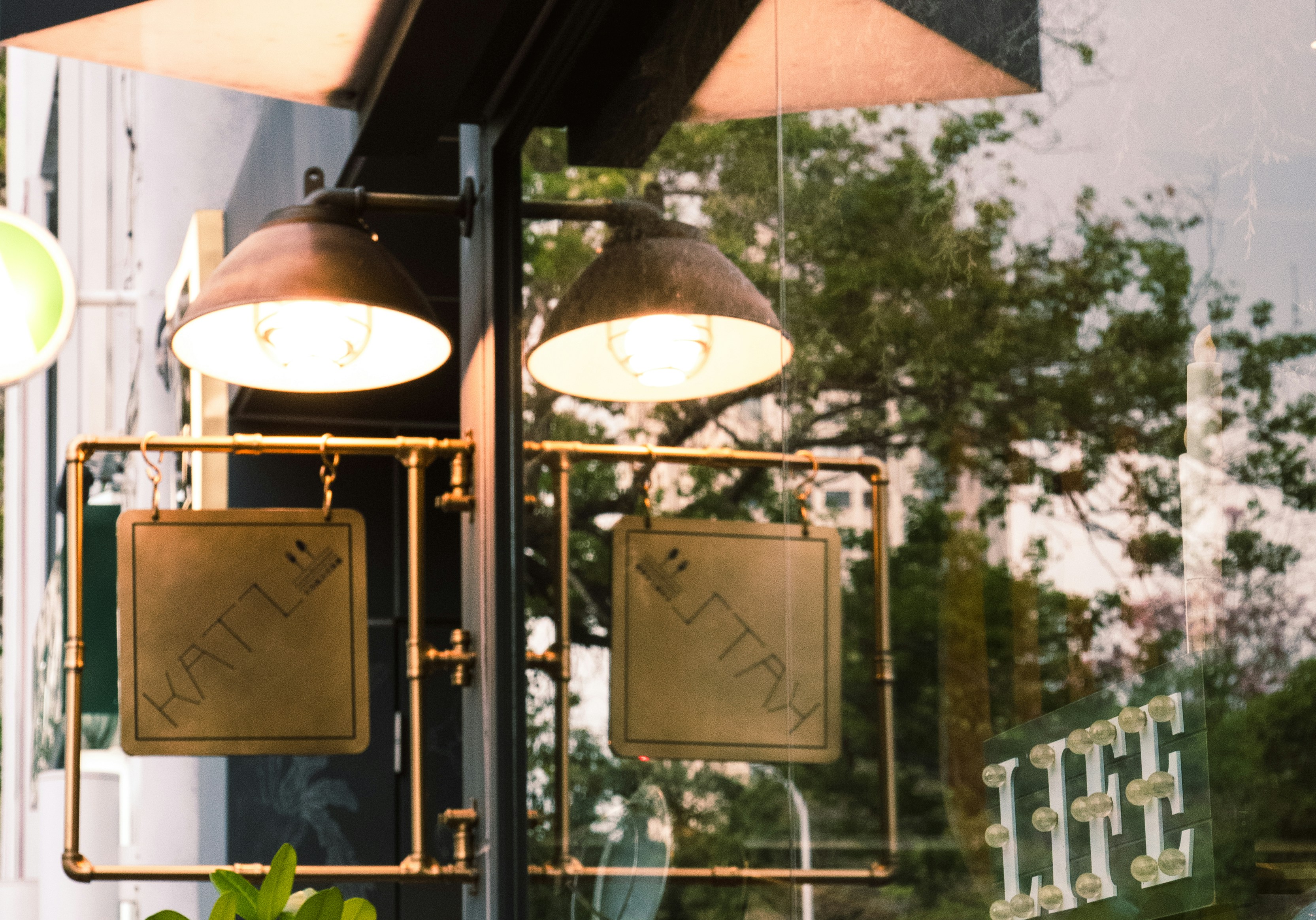 Glass storefront, warm glow, and geometric signage echoing urban life