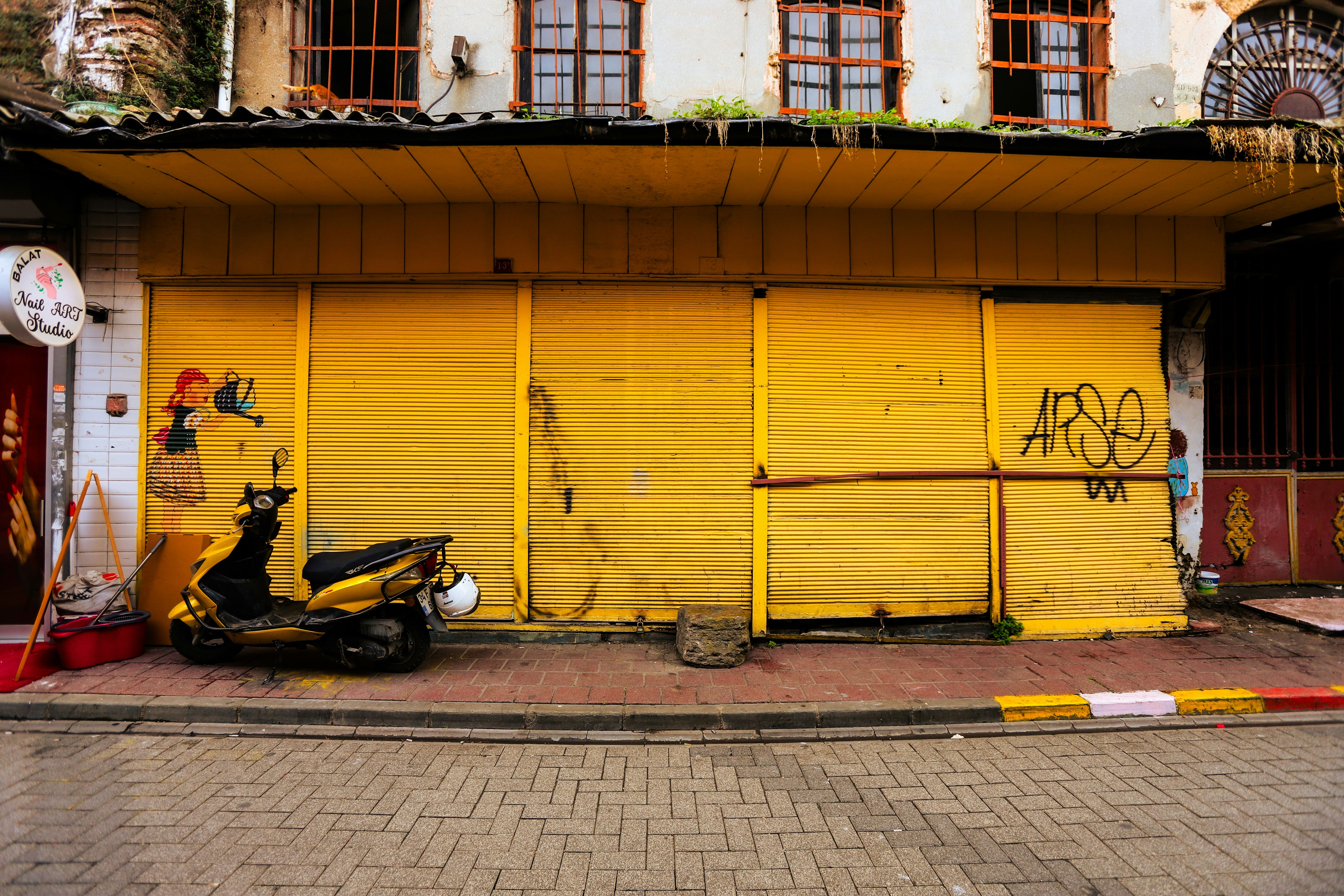 Yellow shutters and scooter on a quiet urban street