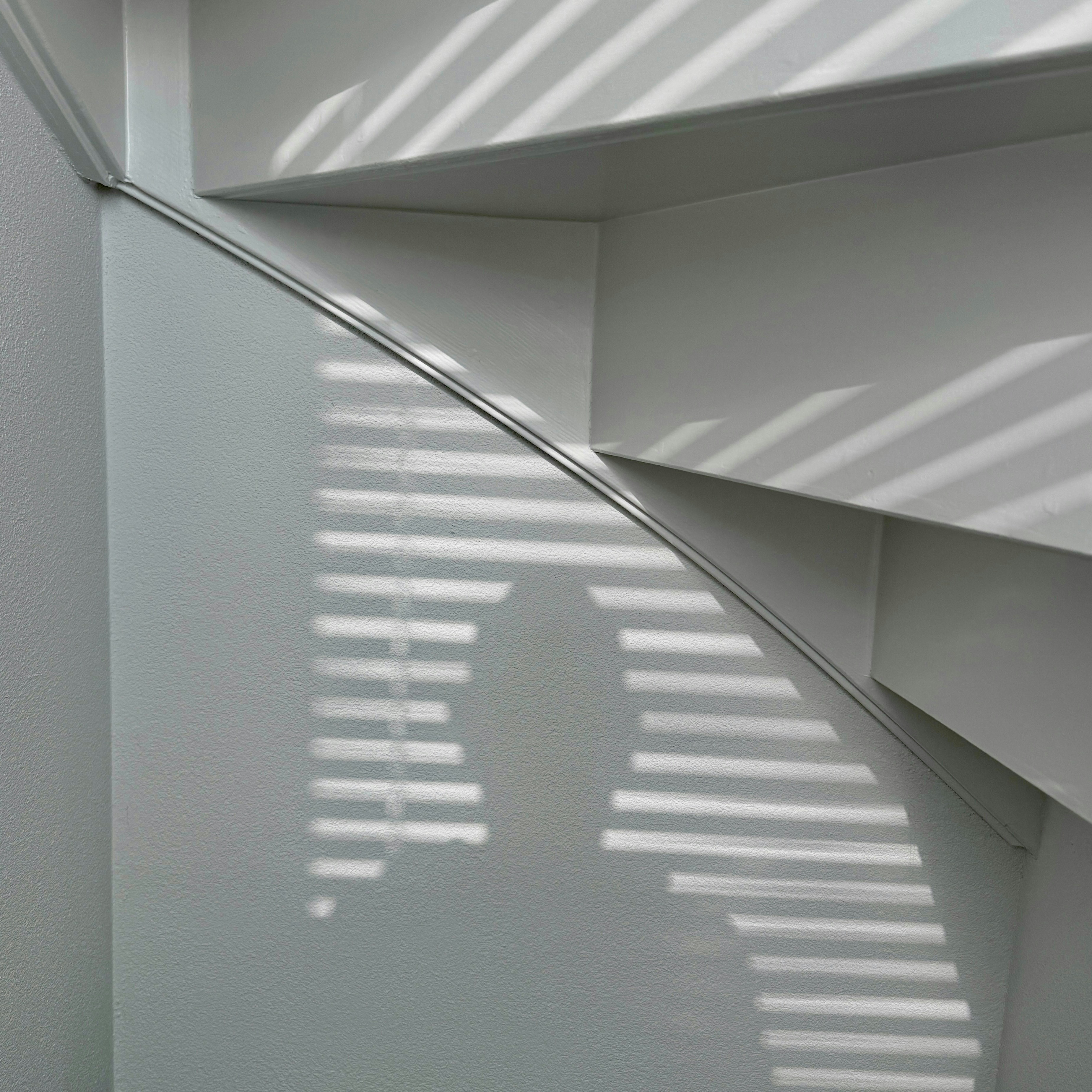 Shadowed Circle: Stairwell Light Through Slats