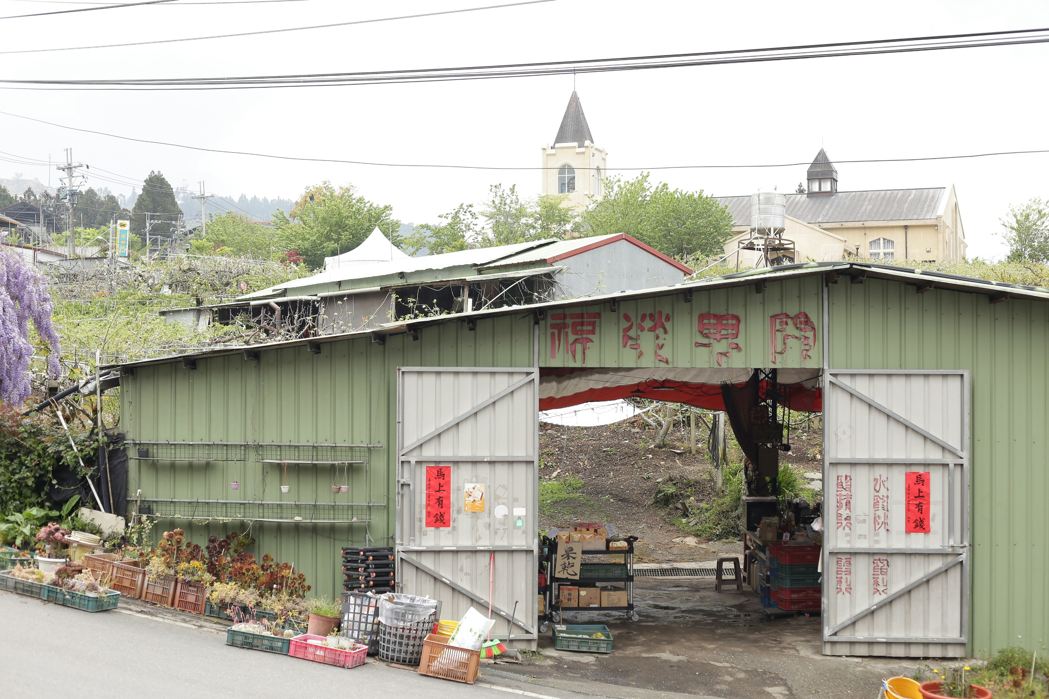 Green Workshop Gate Beneath a Quiet Township Sky