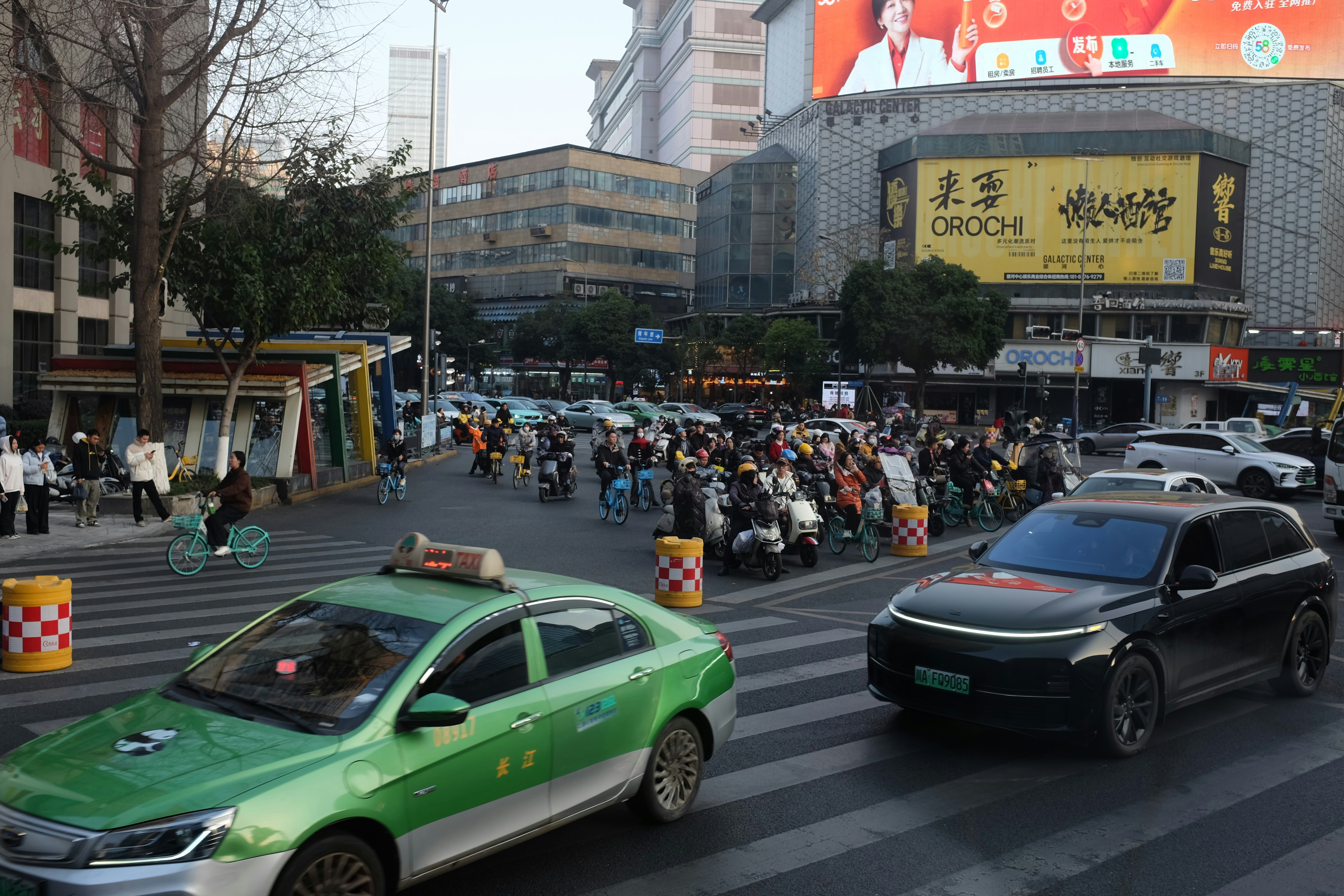Crosswalk Confluence: Green Taxi, Black SUV and a Sea of Pedestrians at a City Center