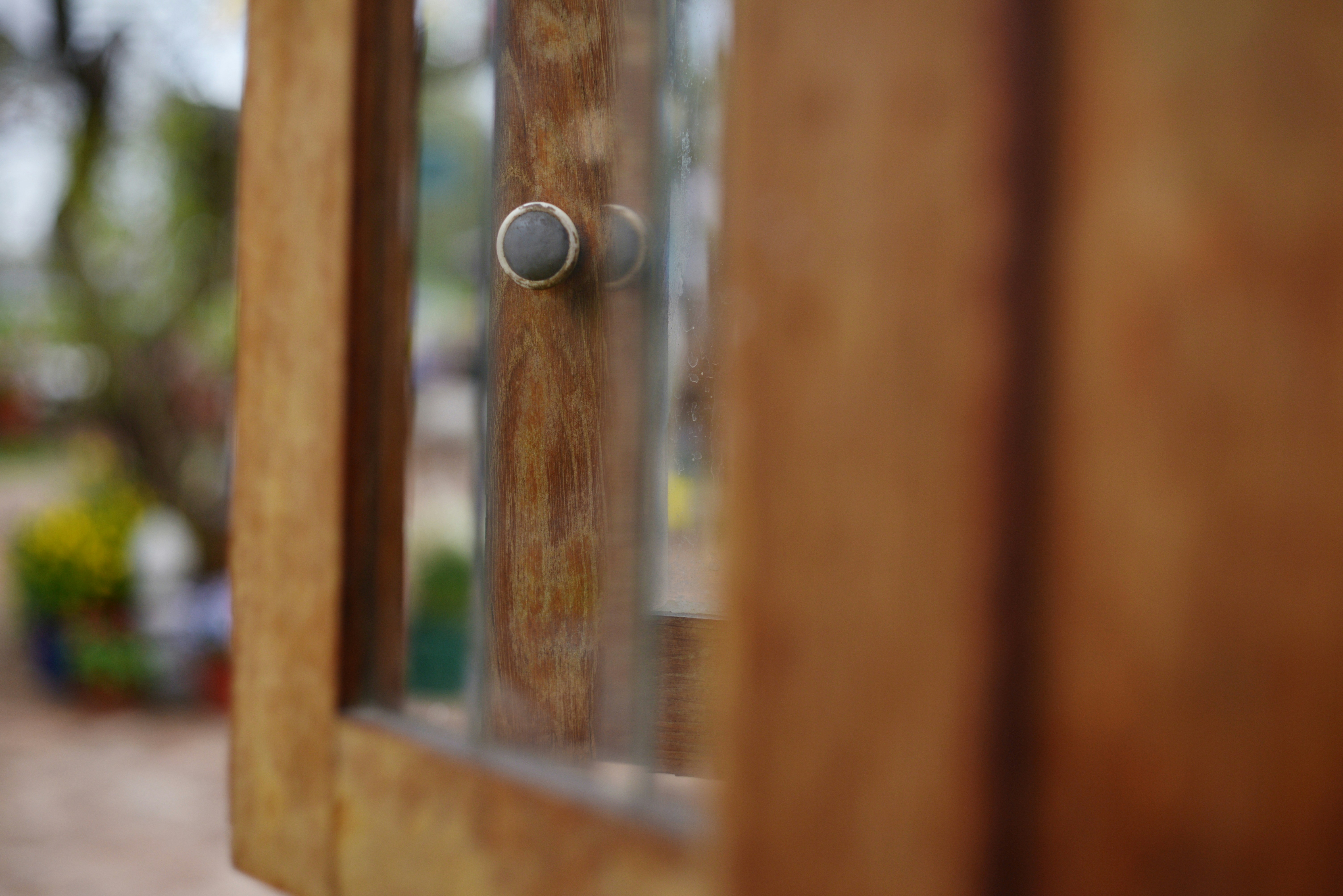 Weathered Doorway: A Glimpse Through a Rustic Window Handle