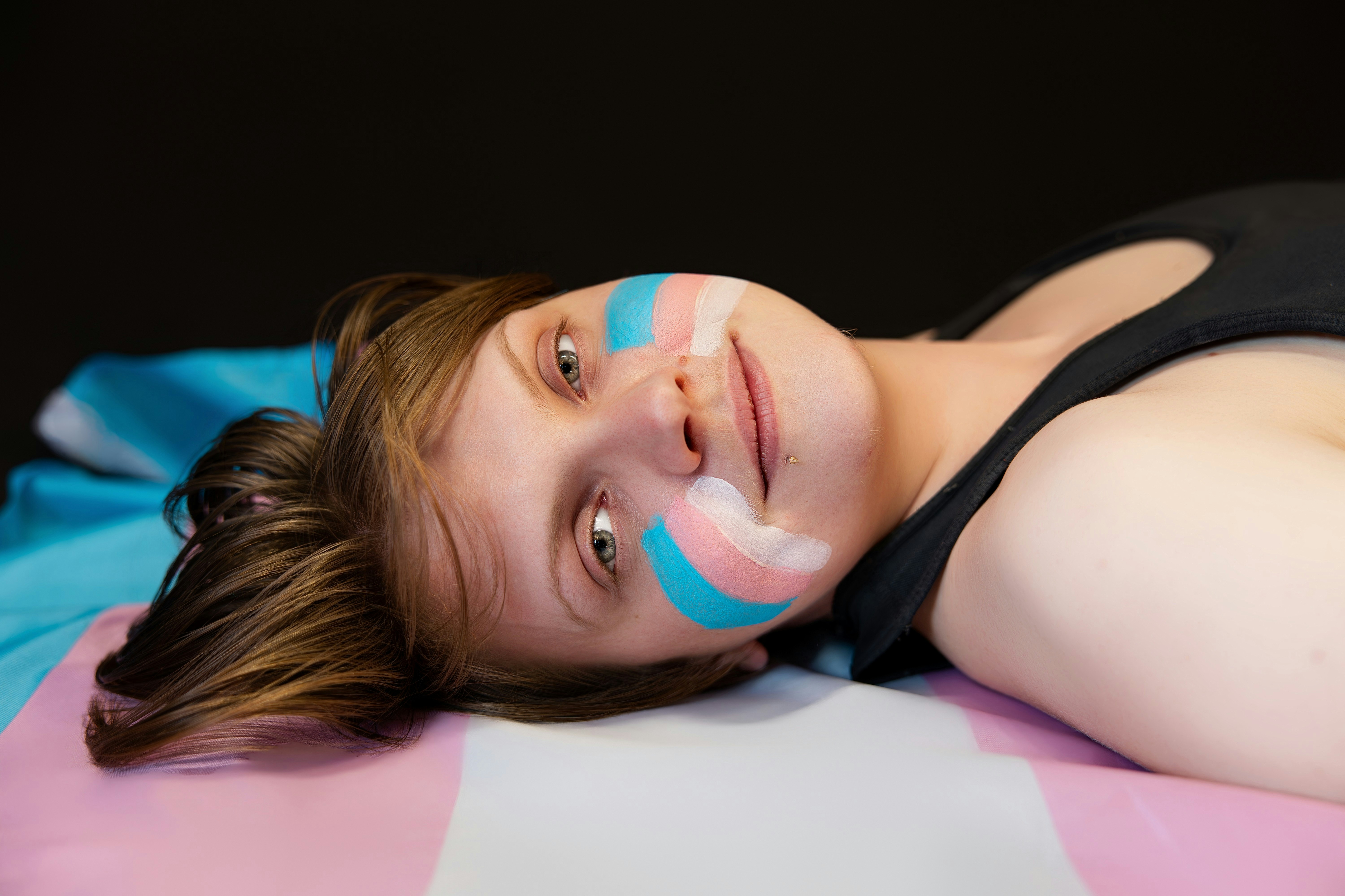 Face Painted with Pride: A Relaxed Portrait on a Colorful Surface