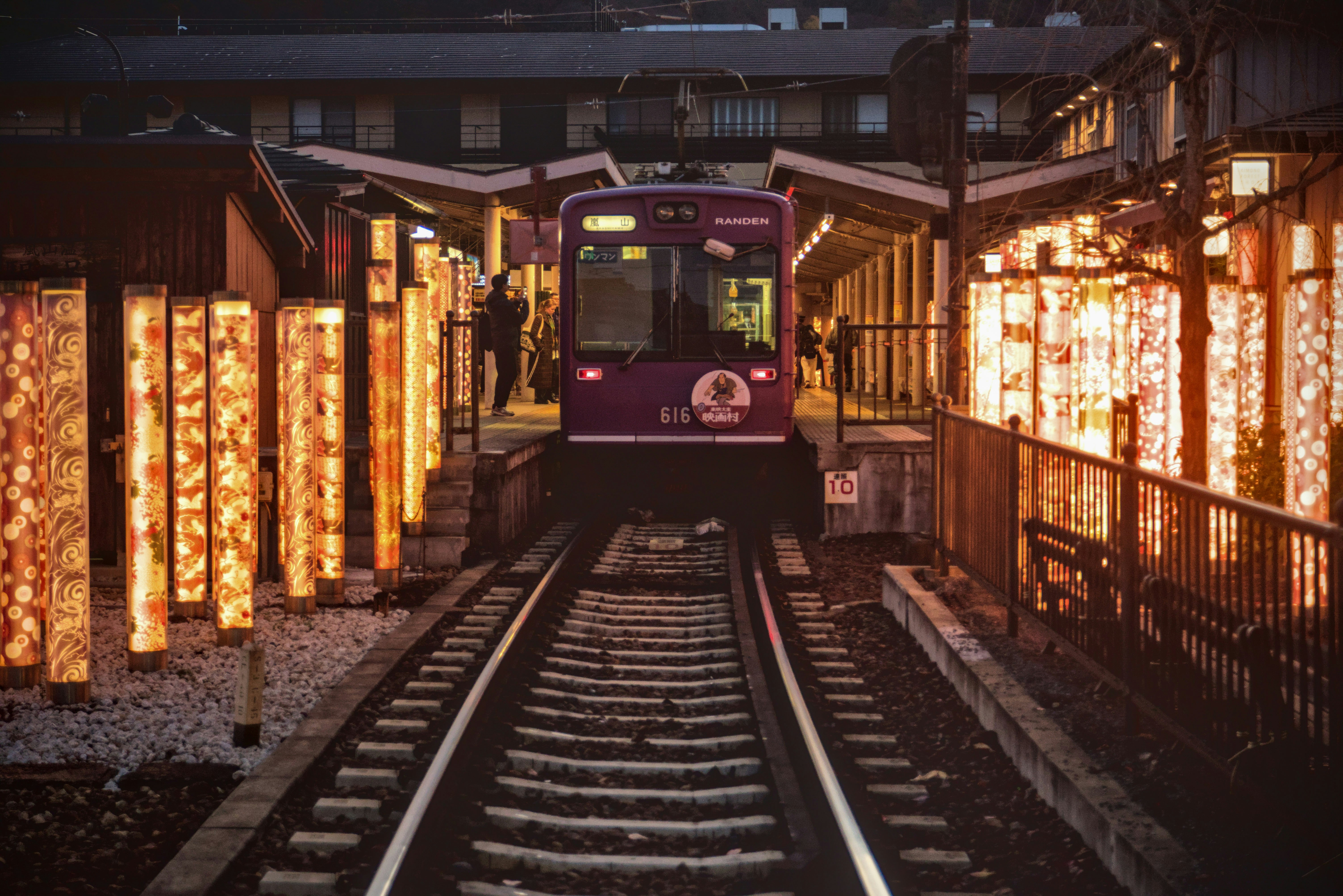 Daybreak on Rails: A Magenta Tram in a Corridor of Lanterned Oranges