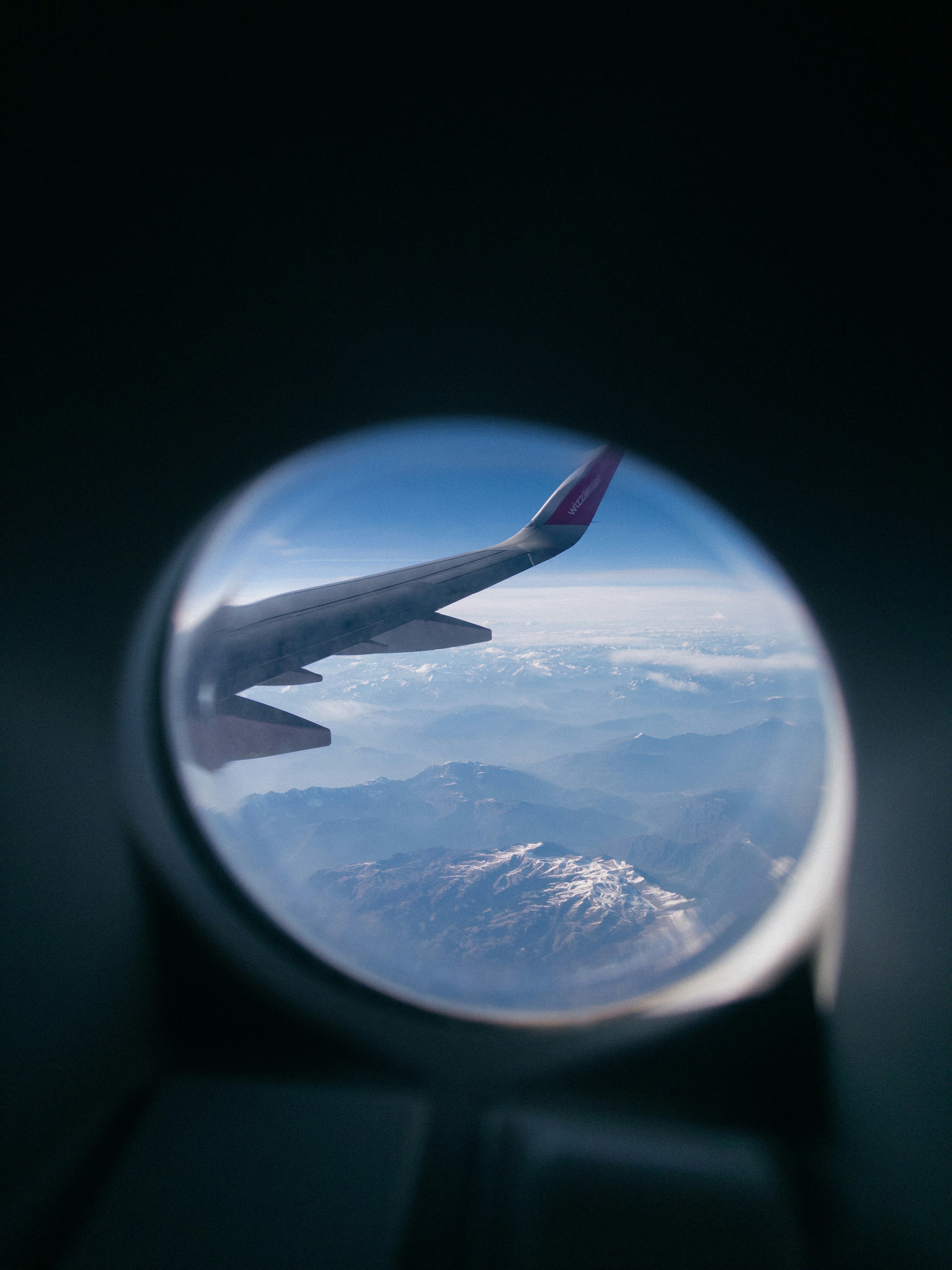 Window to the Sky: A Wing's View Across Snow-Capped Peaks