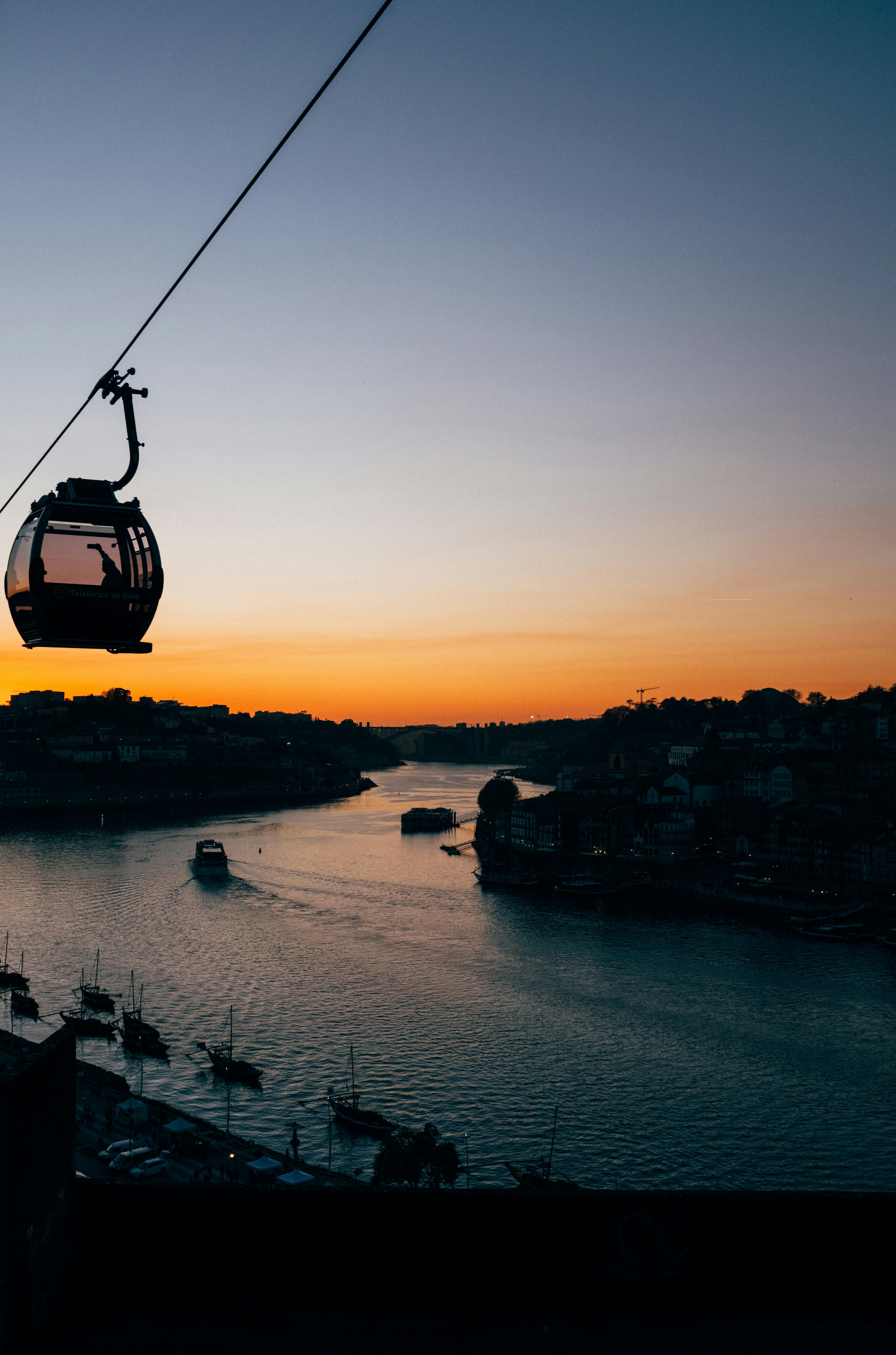 Skyline in Suspension: A Sunset Gondola Over a Quiet River