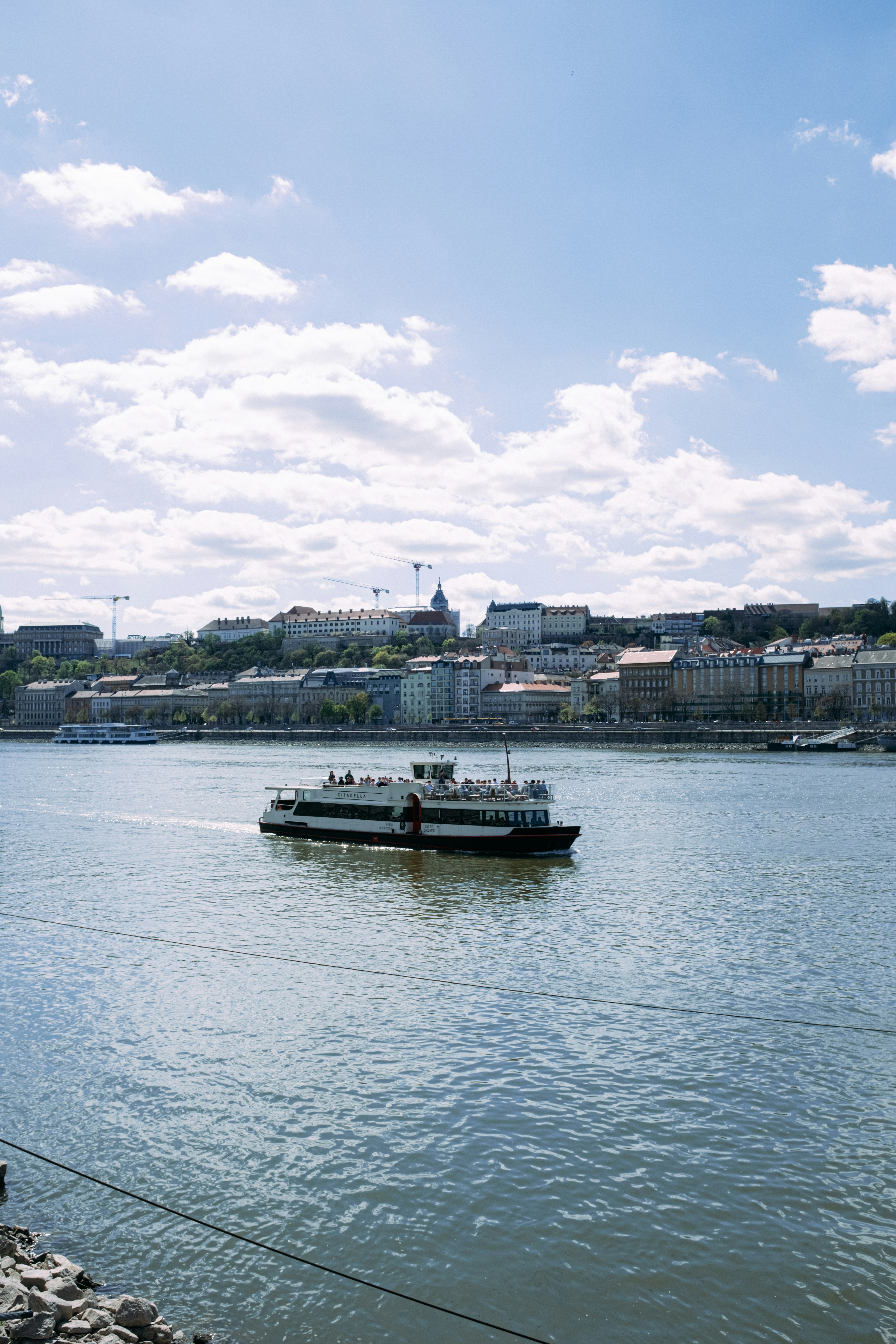 City on the Waterfront: A Boat Gliding Past a Terrace of Distant Buildings