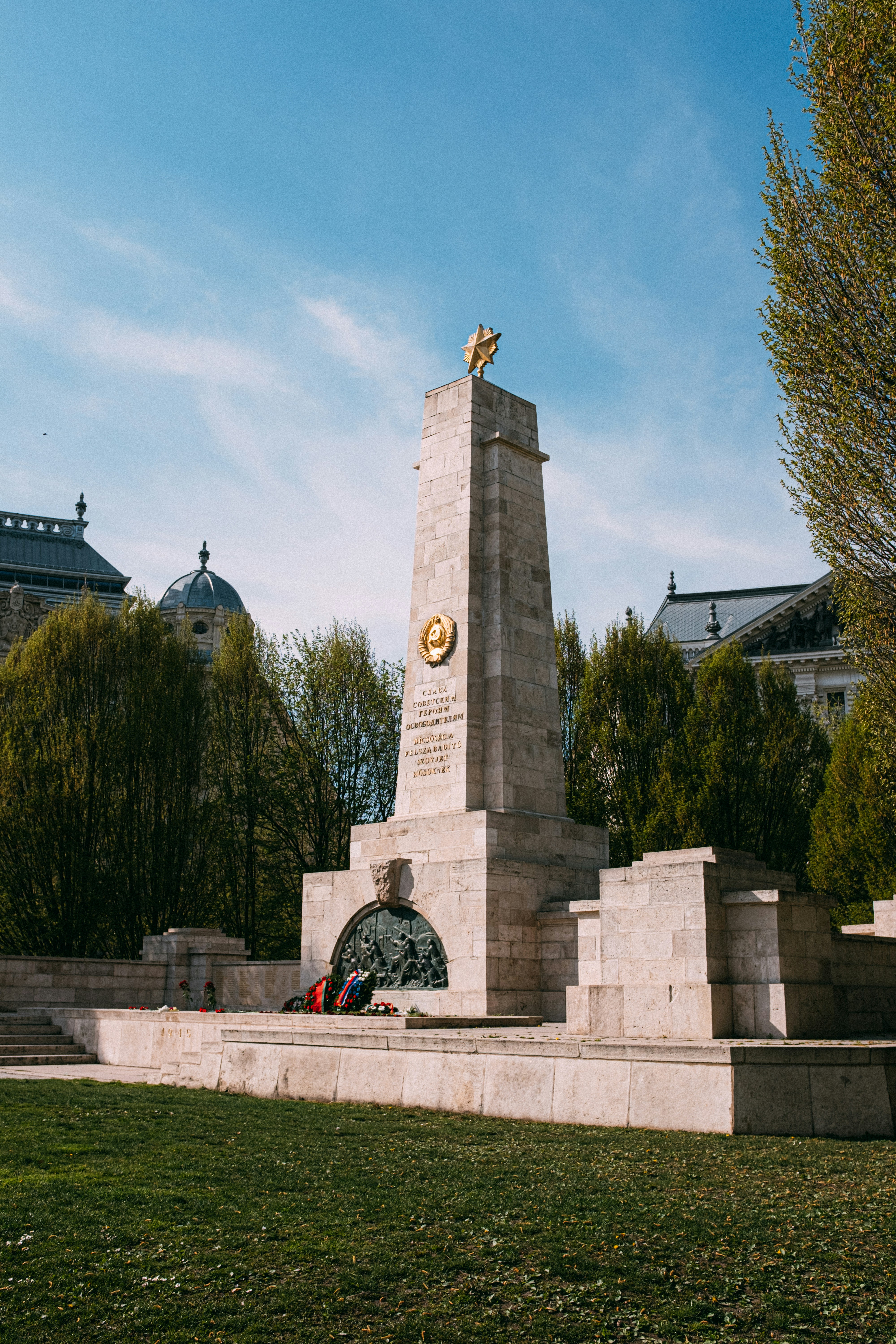 Stone Obelisk Rising Above a Parked Memorial Lawn