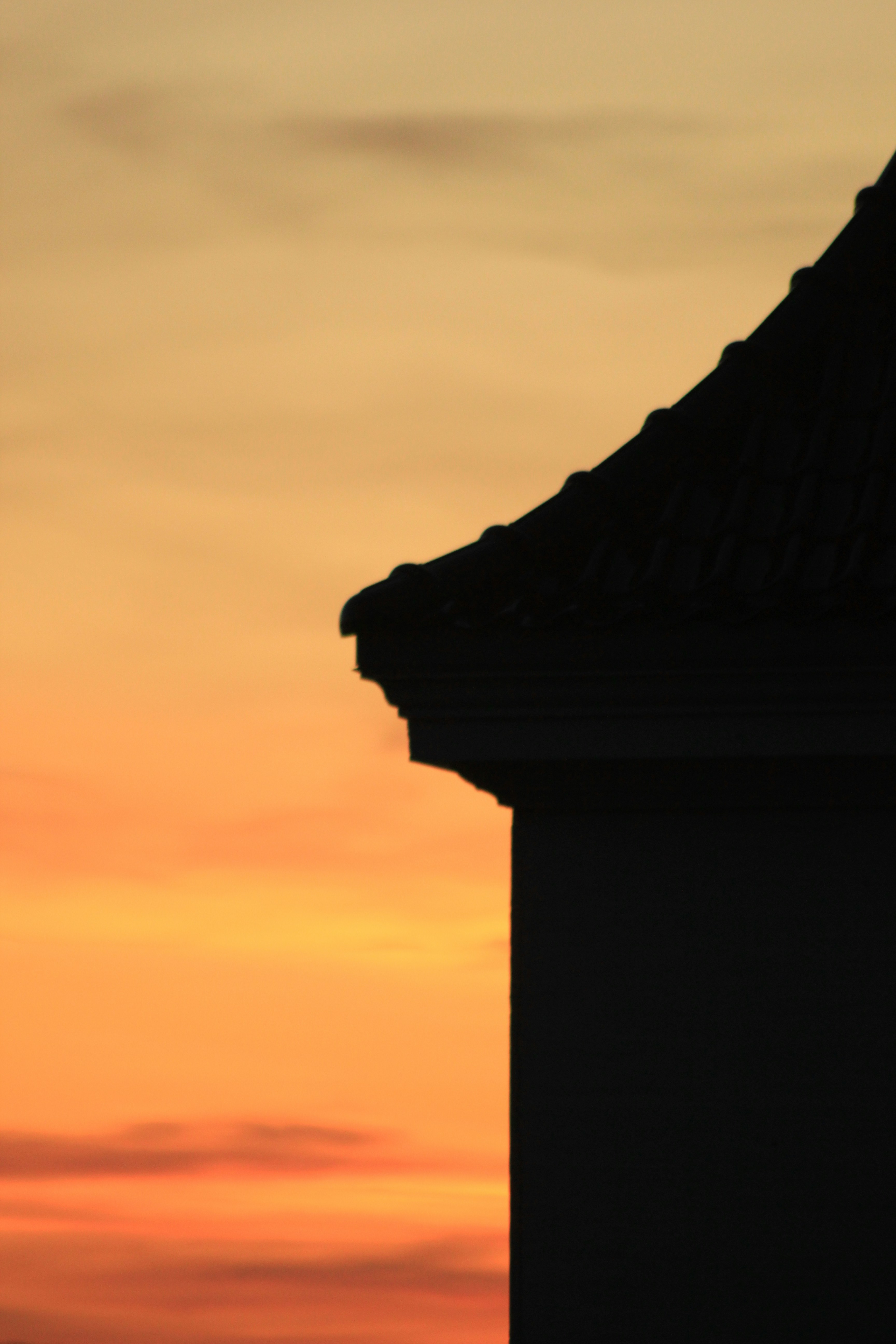 Silhouette at Sunset: A Corner of the Roof Against Warm Skies