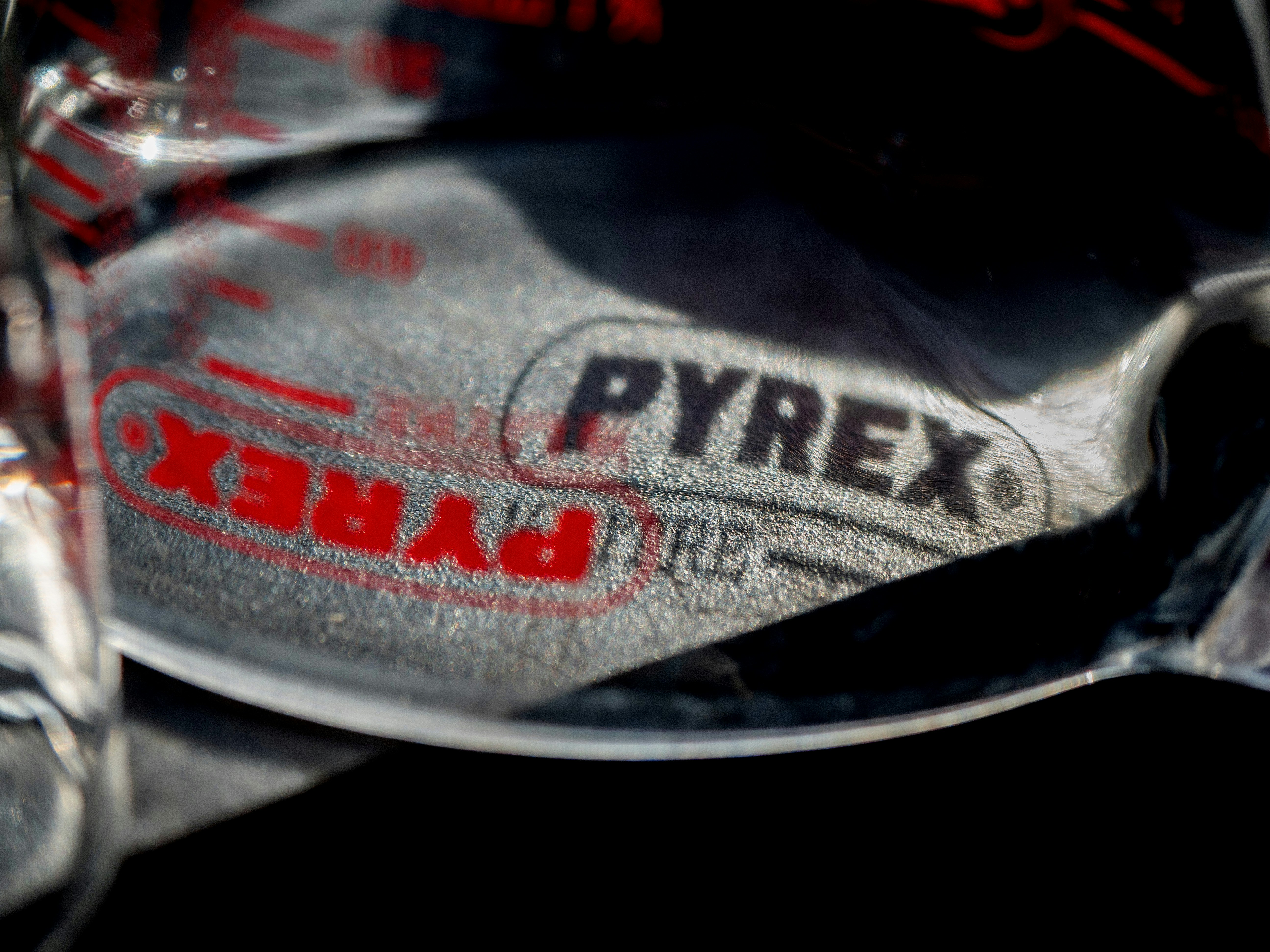 Cracked Glass, Reflected Label: Pyrex and Red Branding in Macro Light