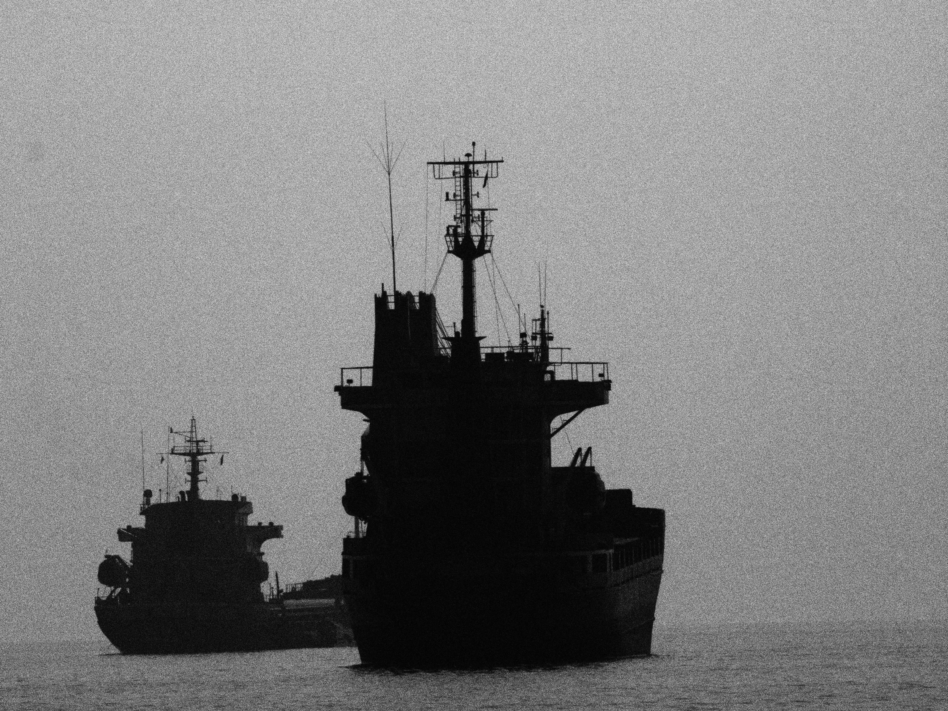 Dark Convoy: silhouettes of harbor vessels cutting through fog