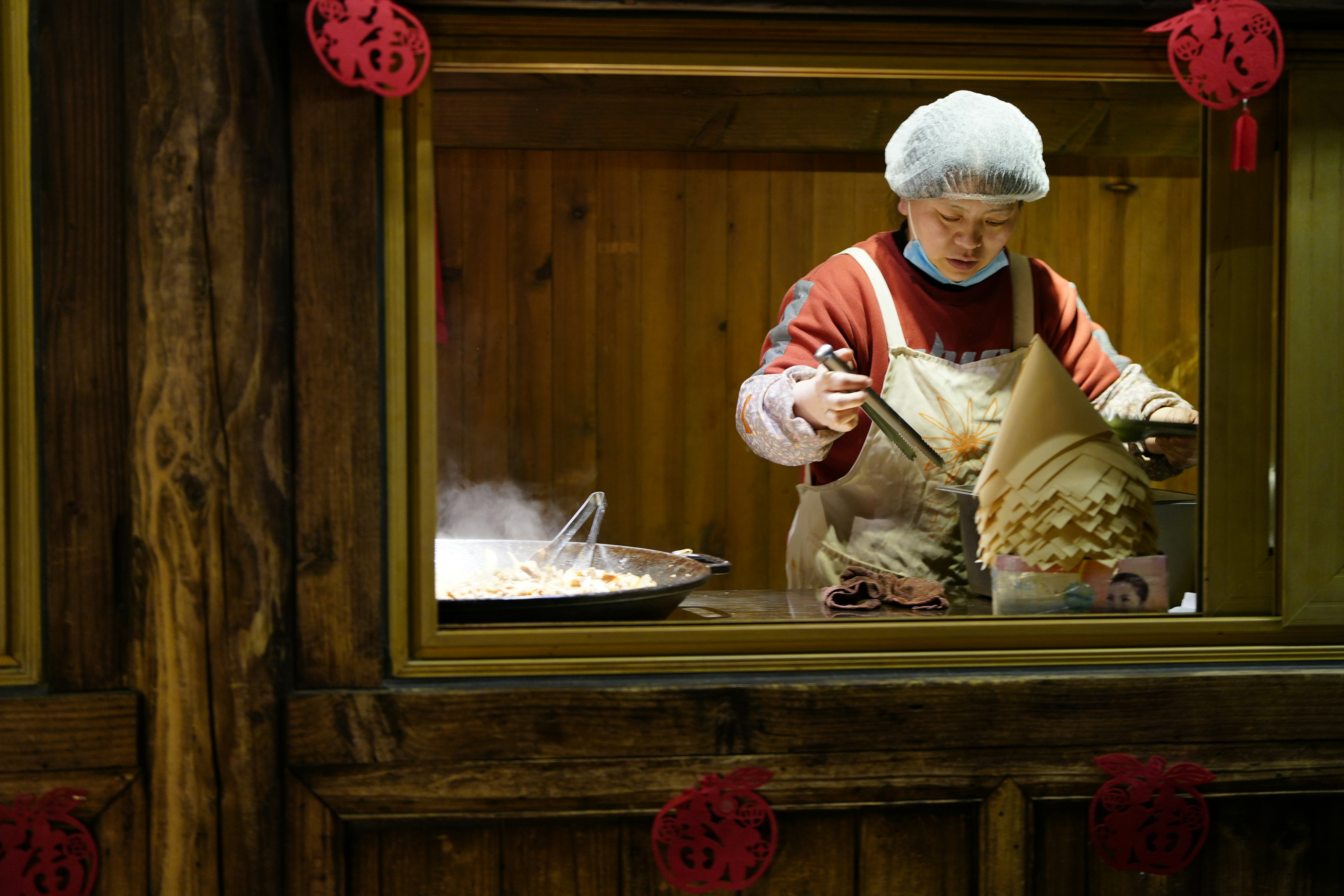 Stirring Steam: A Skillful Vendor in a Wooden Window