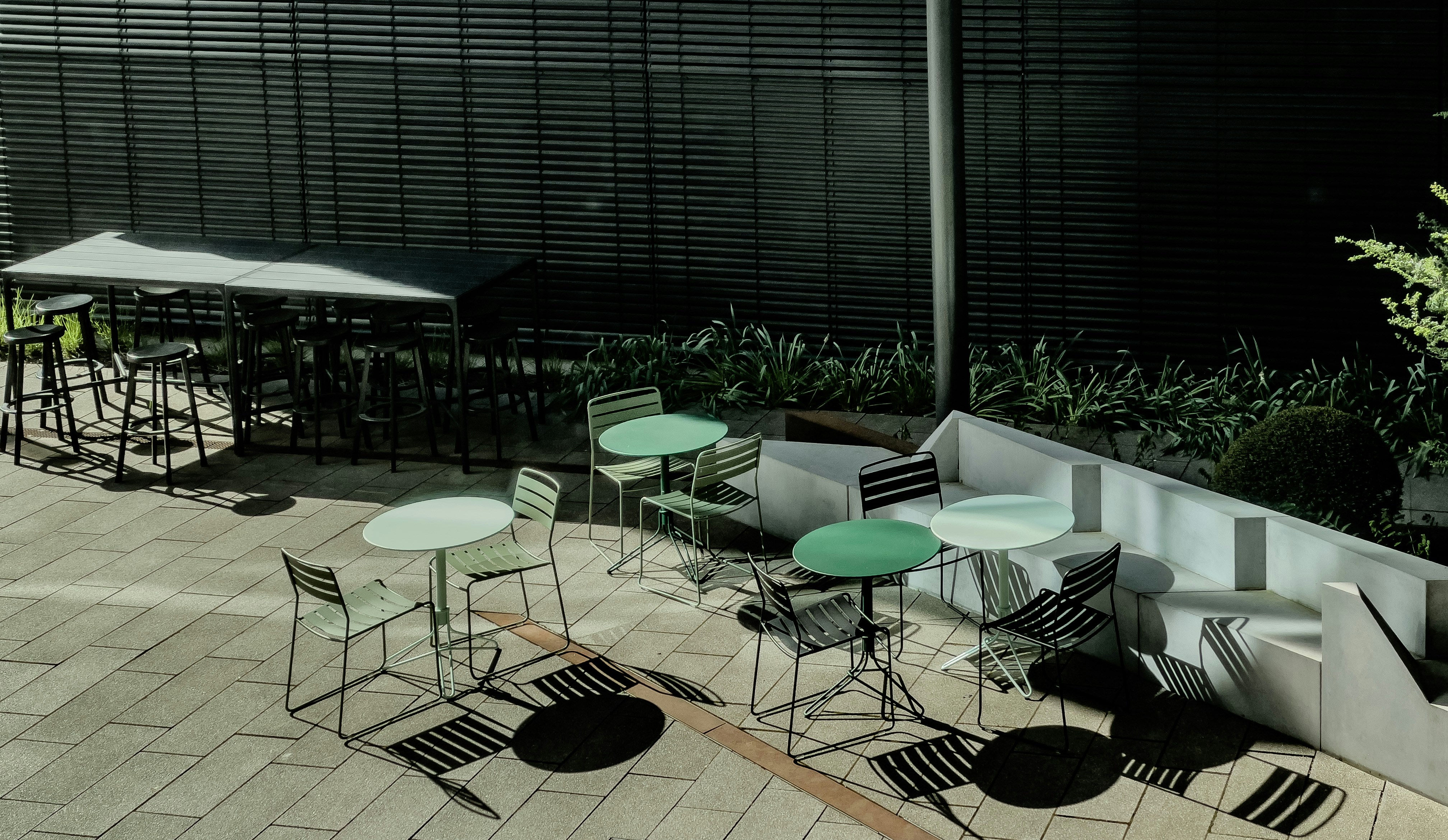 Shaded Café Ballet: Green Tables and Shadowed Circles