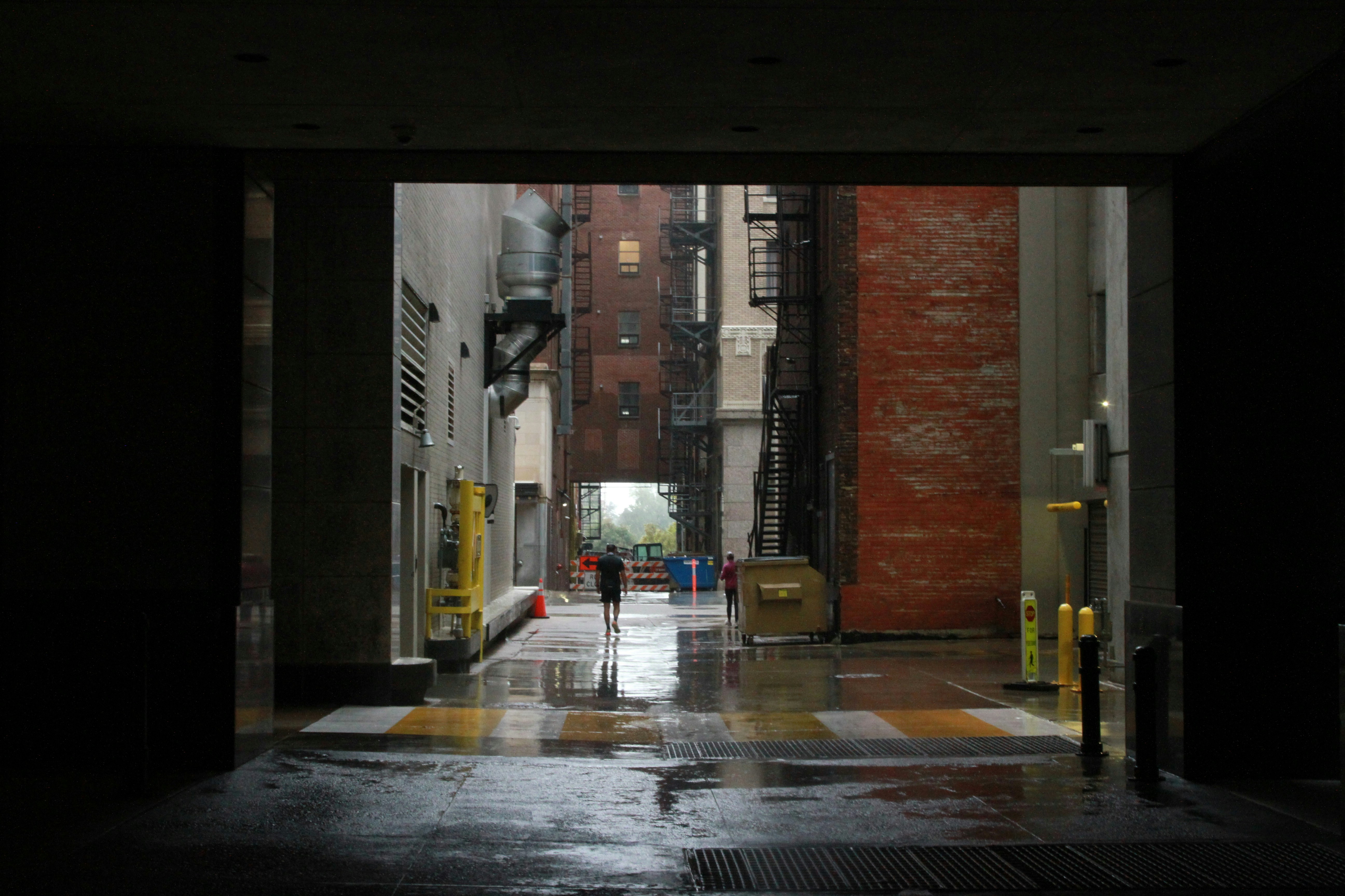 Backlit Alleyway: Two Figures at the Threshold of Light