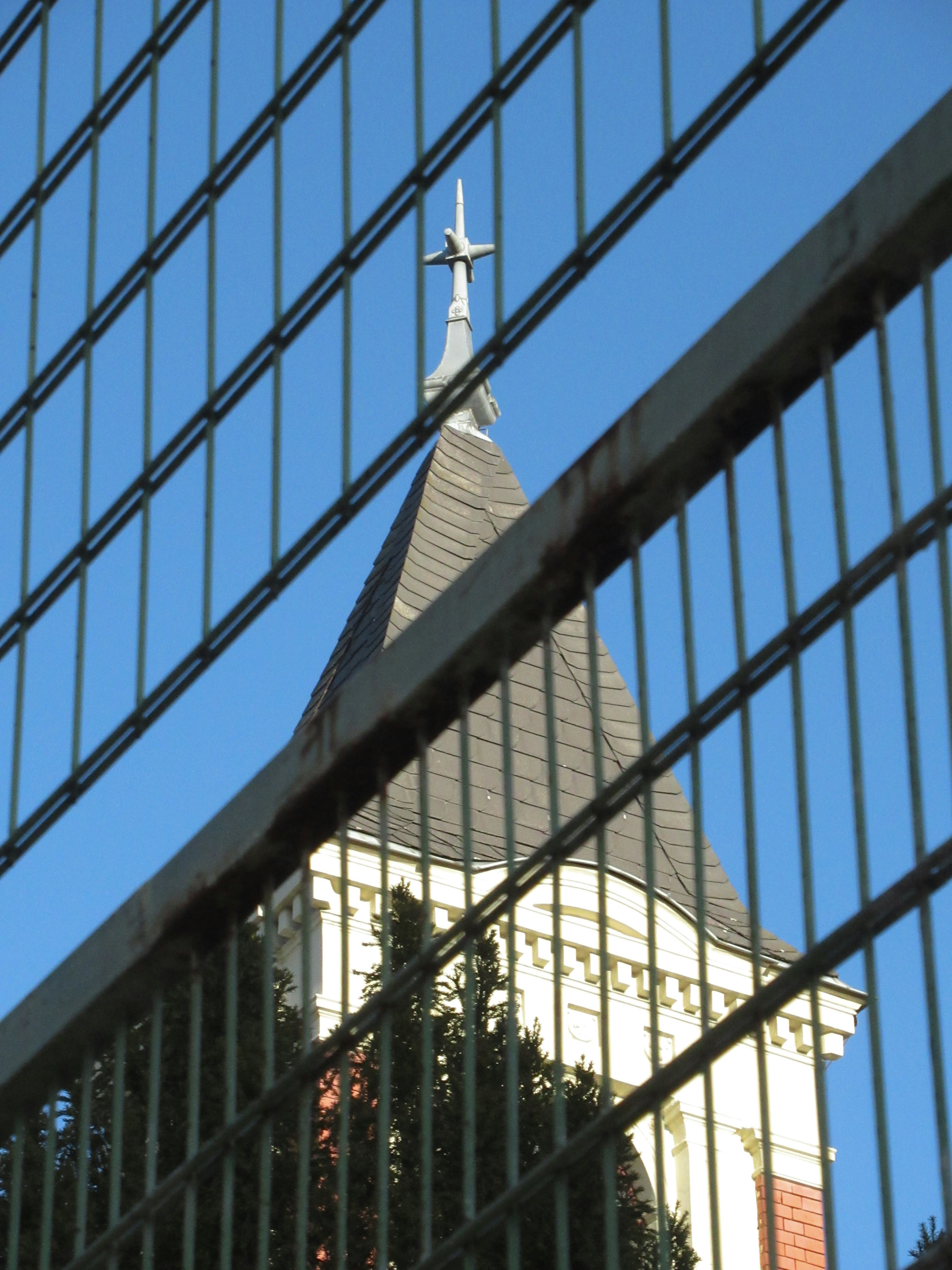 Crossing Grilles: Church Spire Pierced by Fence