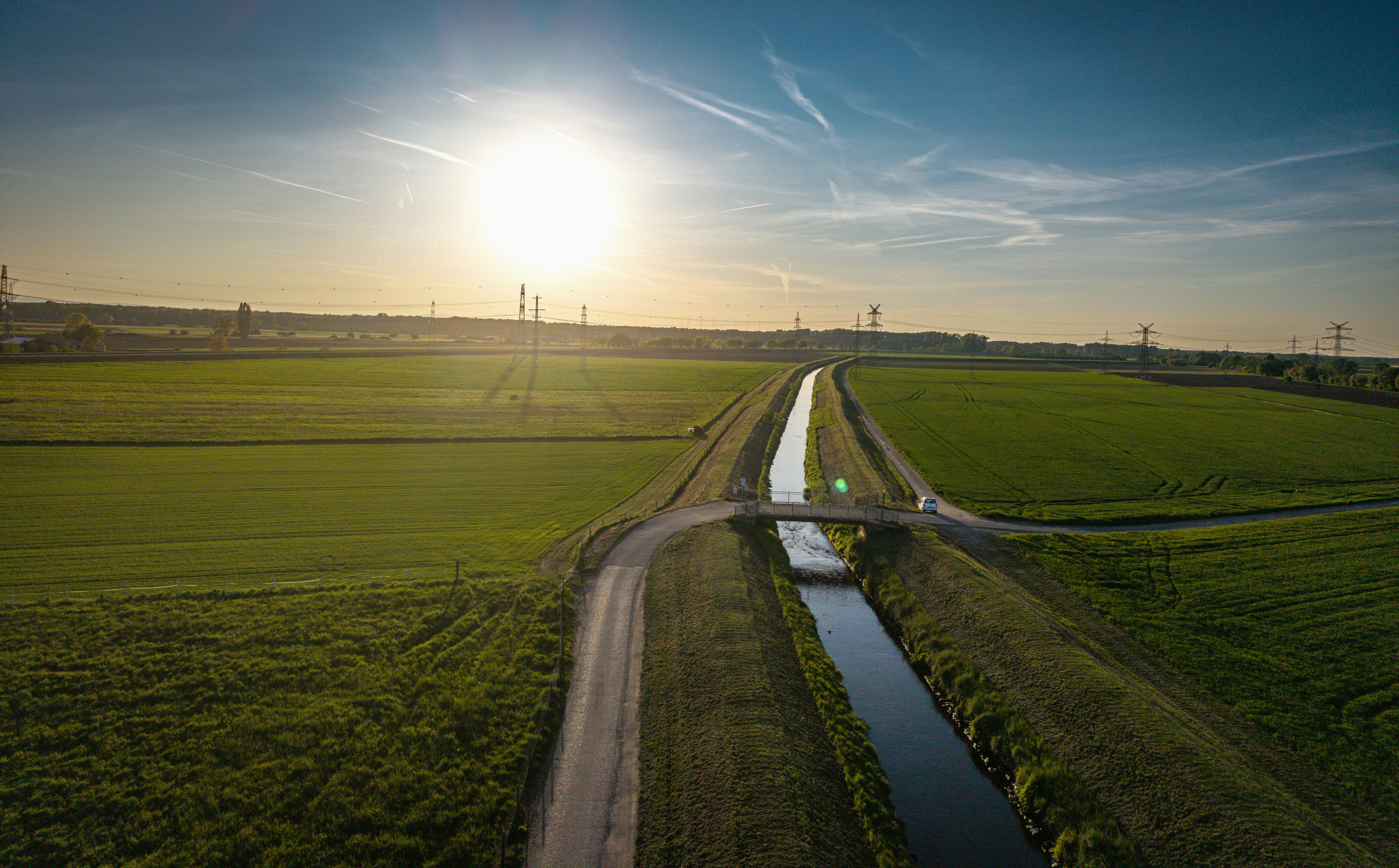Sunlit Canal and Farmland: A Quiet Arc from Field to Horizon