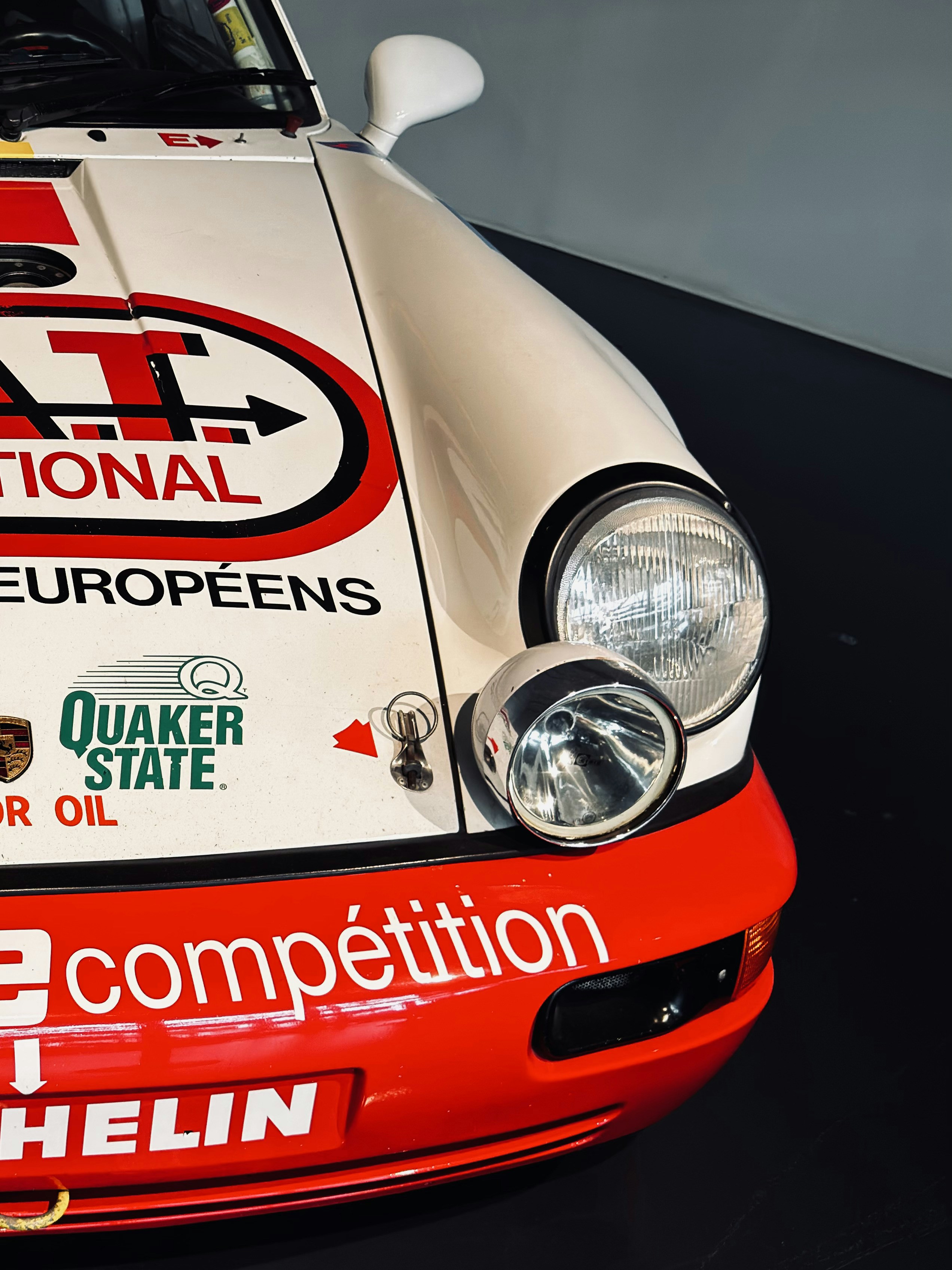 Front-Left Rally Portrait: A Race-Tuned Car Emerges from the Shadows