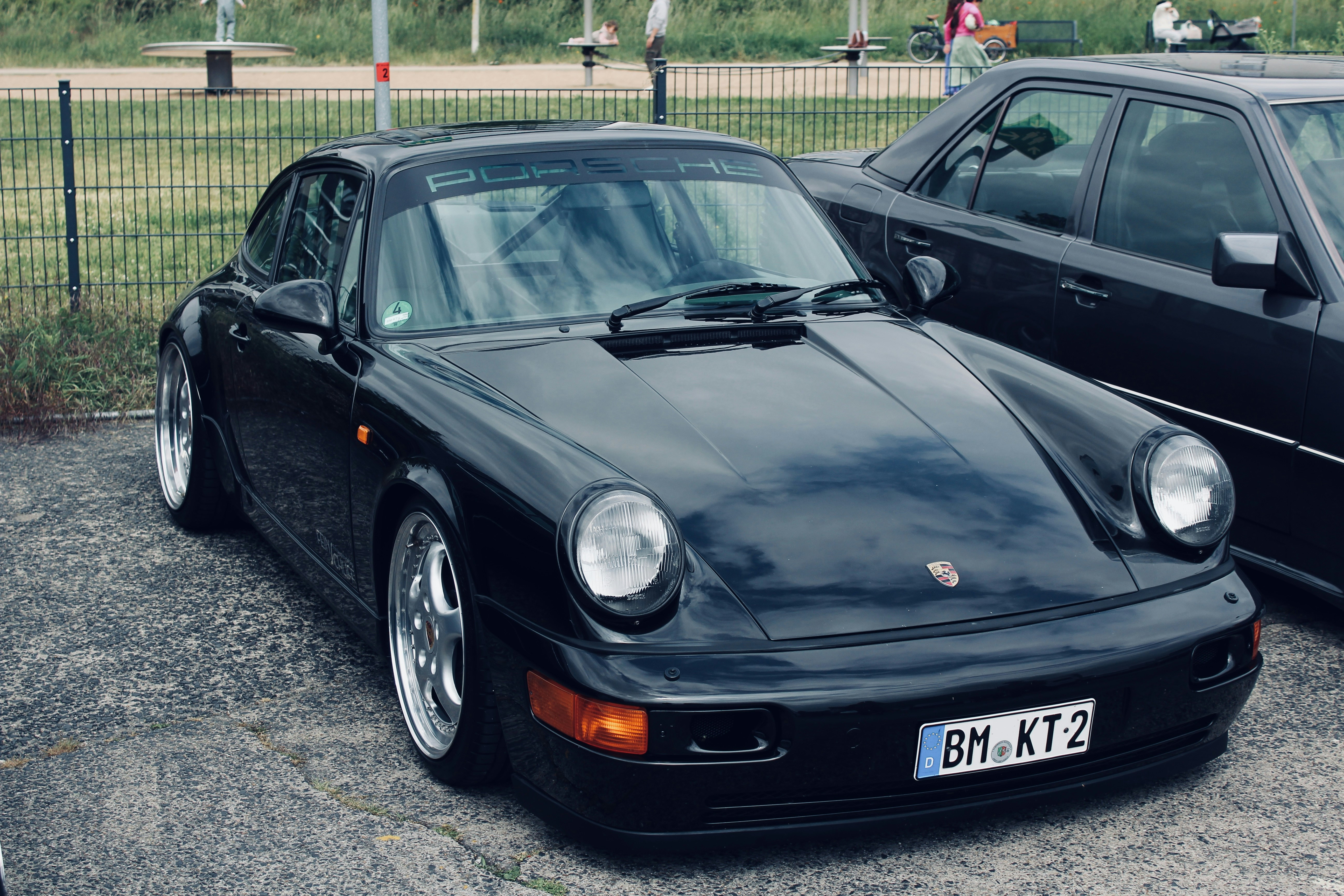Low-slung midnight: a classic Porsche lounging in a parking lot
